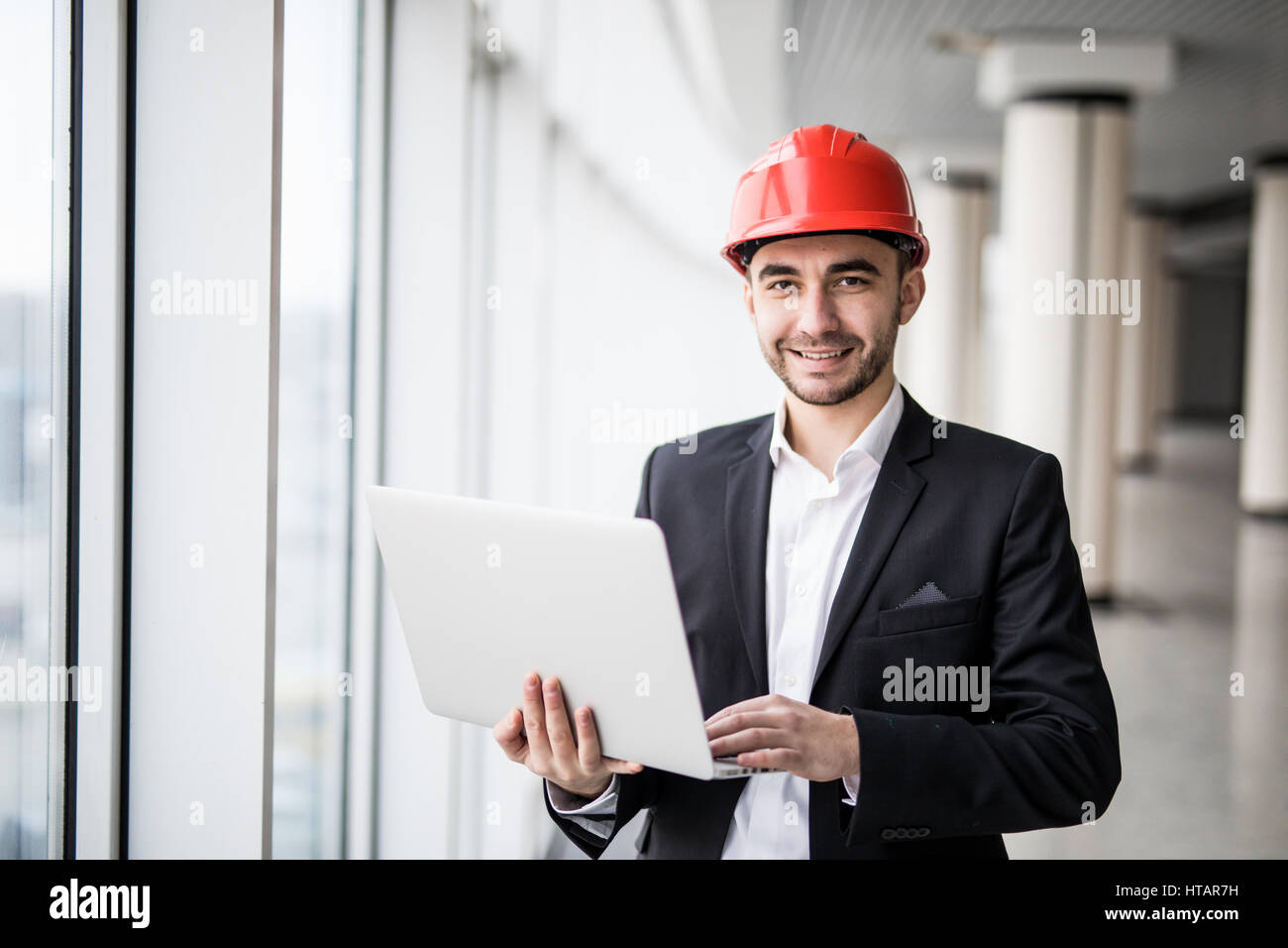 Handsome male engineer is using a notebook for work. The man is a white ...