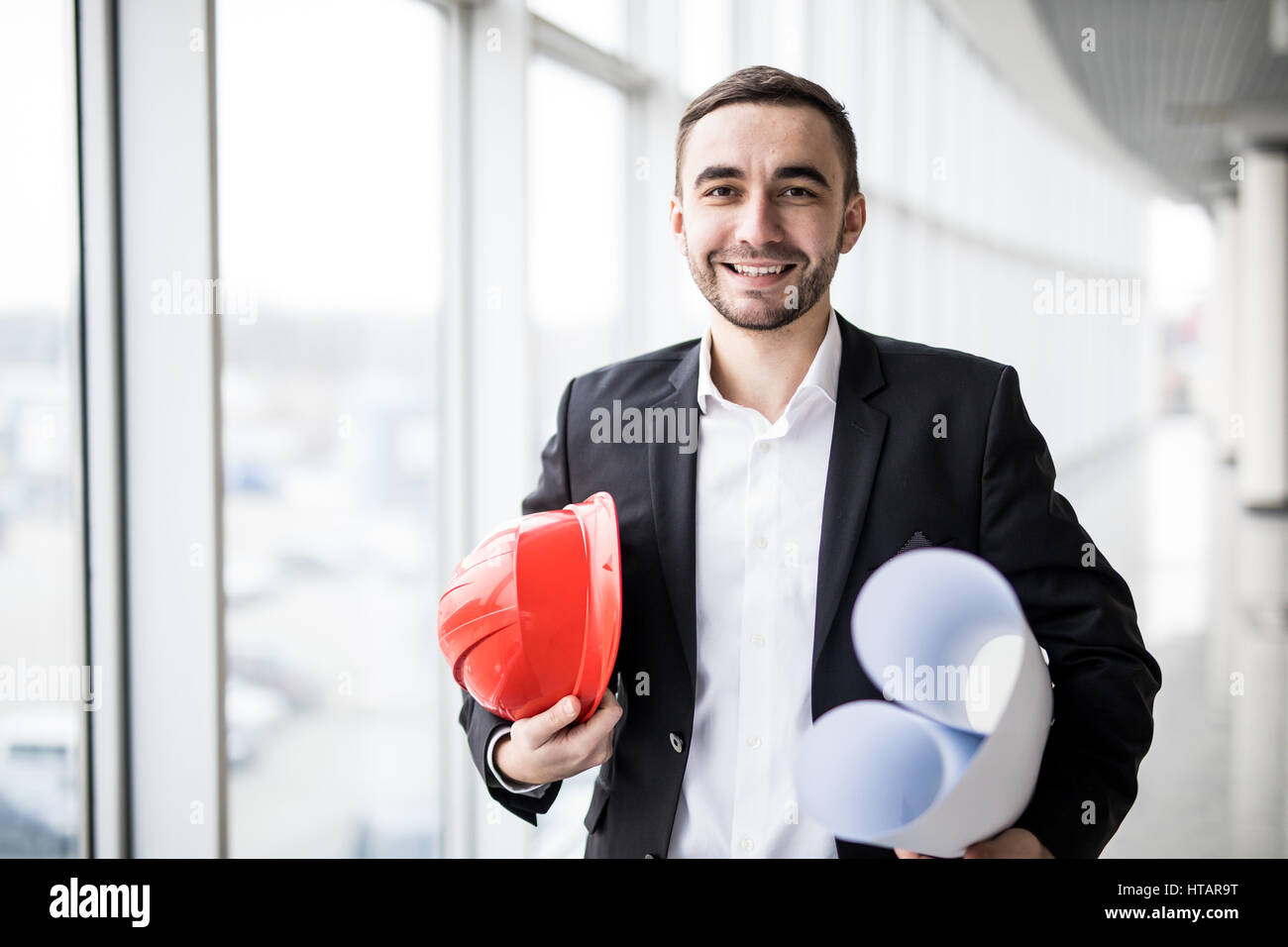 young architect holding blueprint and hamlet in office renovation ...