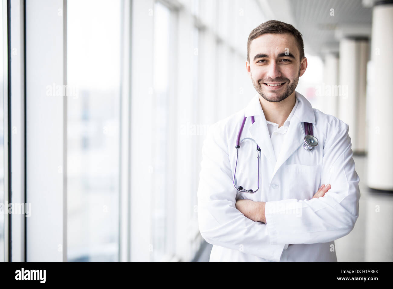 Attractive young handsome doctor in clinic hall Stock Photo - Alamy