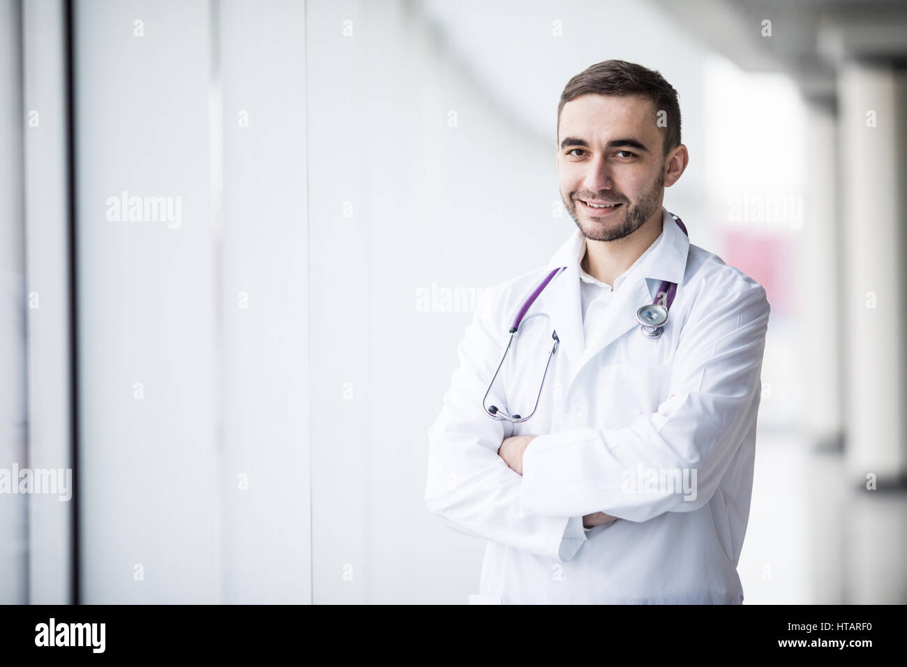 Attractive young handsome doctor in clinic hall Stock Photo - Alamy