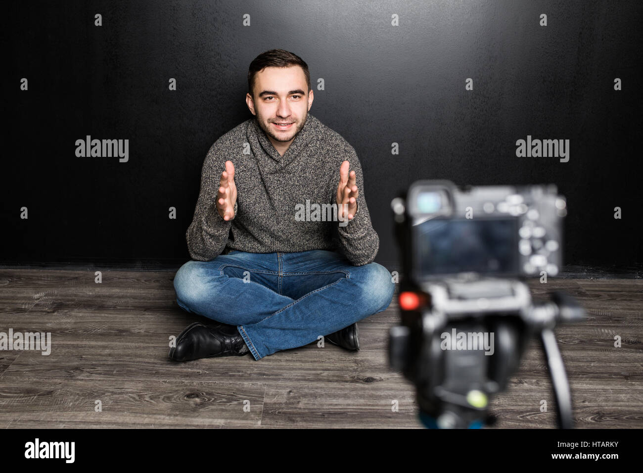 Young man in focus on digital camera LCD screen waving hand while ...