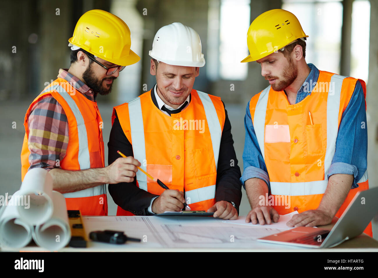 Team of construction workers wearing protective helmets and vests ...