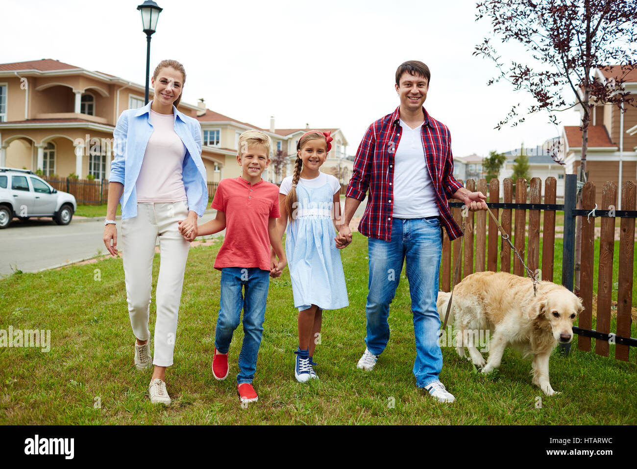 Portrait of happy family with two children, boy and girl, walking their ...