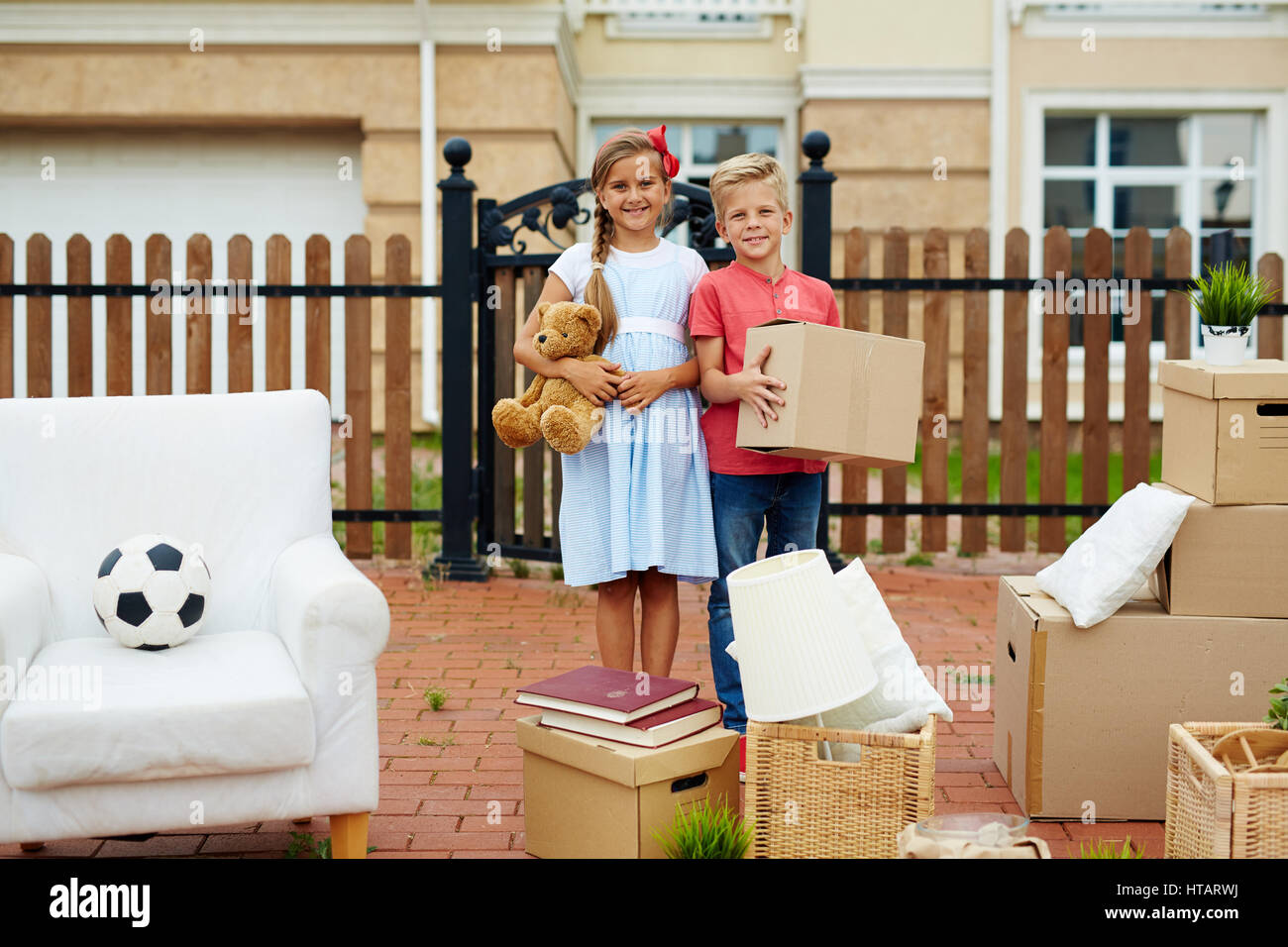 Portrait of neat happy children, boy and girl, standing holding ...