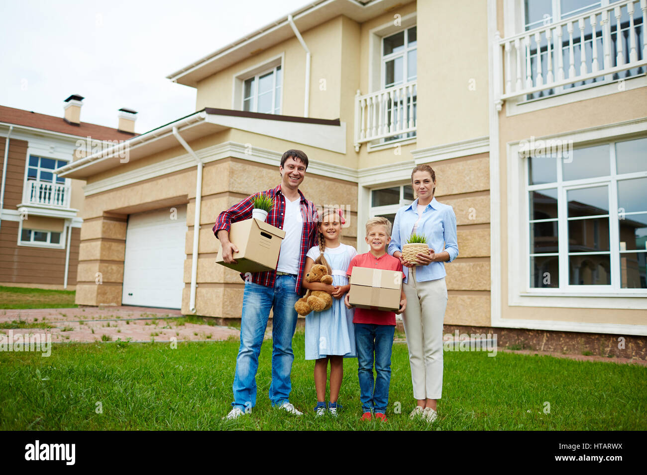 Portrait of successful family with two children standing together ...