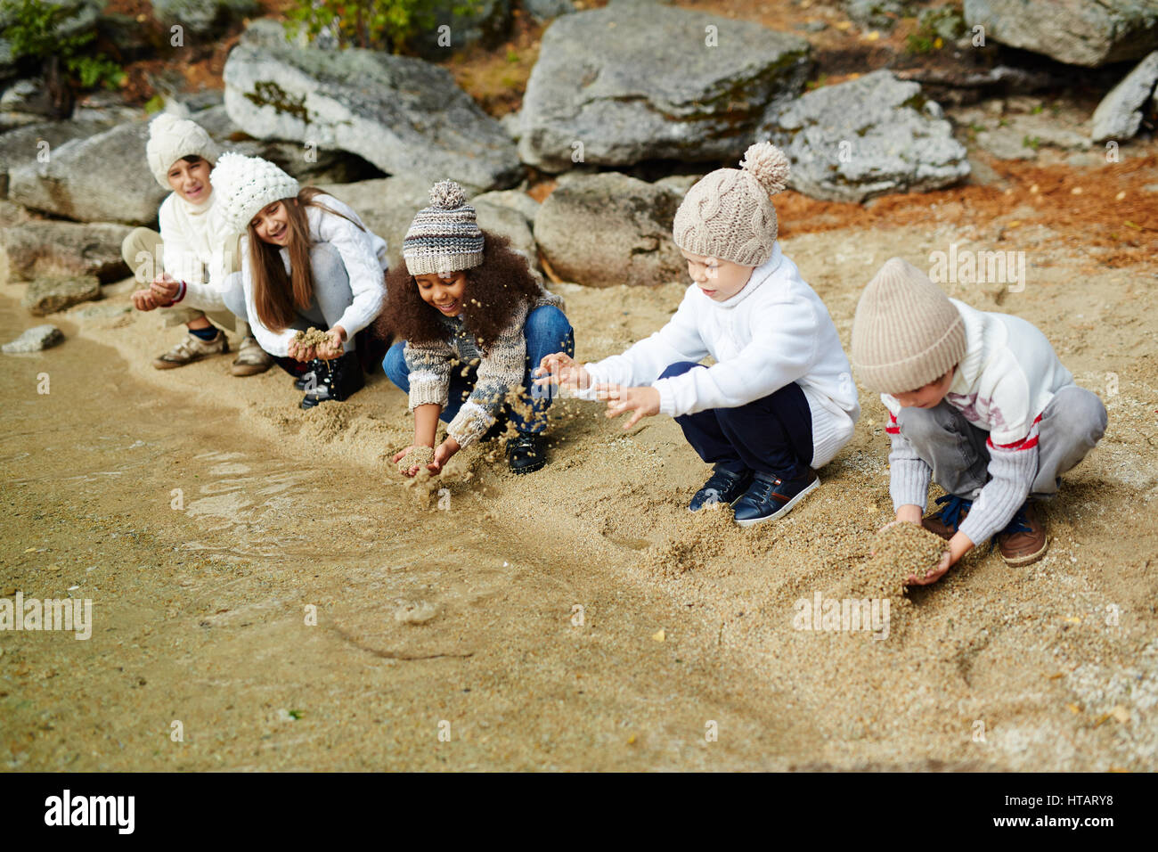 Group of kids playing by water on sand Stock Photo - Alamy