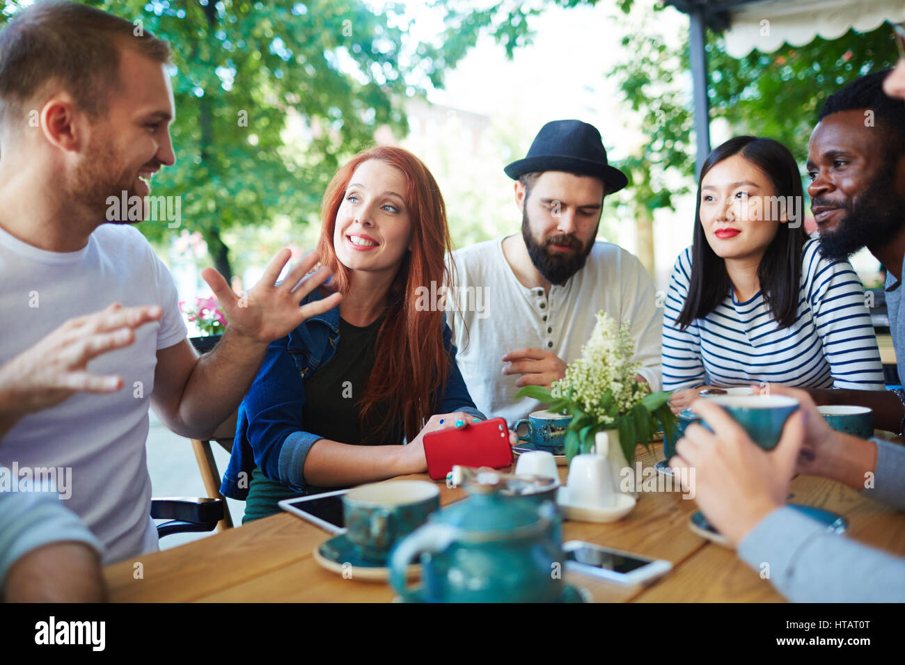 Group of contemporary young people having conversation at hangout Stock ...