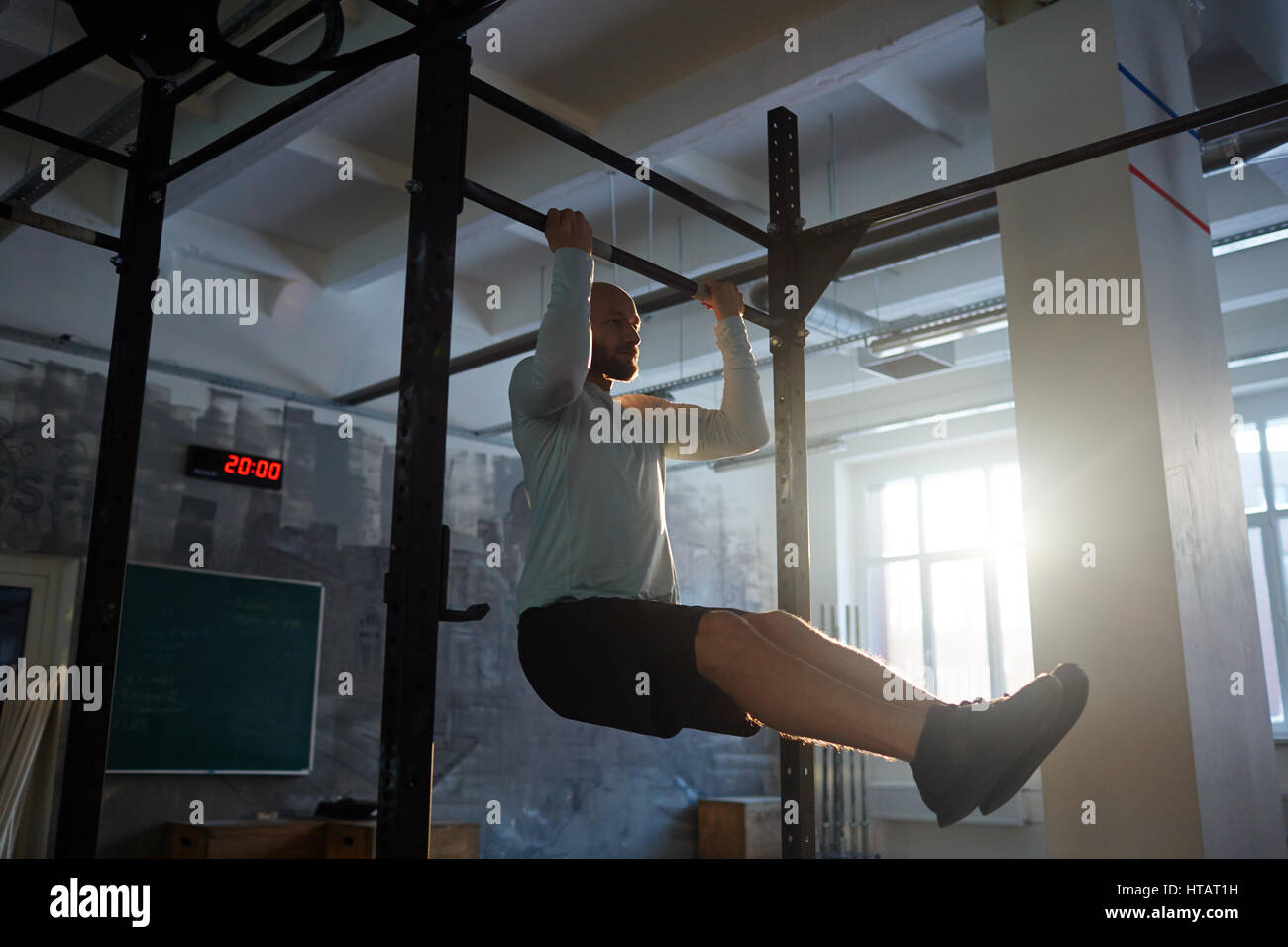 Young athlete exercising on bars in gym Stock Photo - Alamy