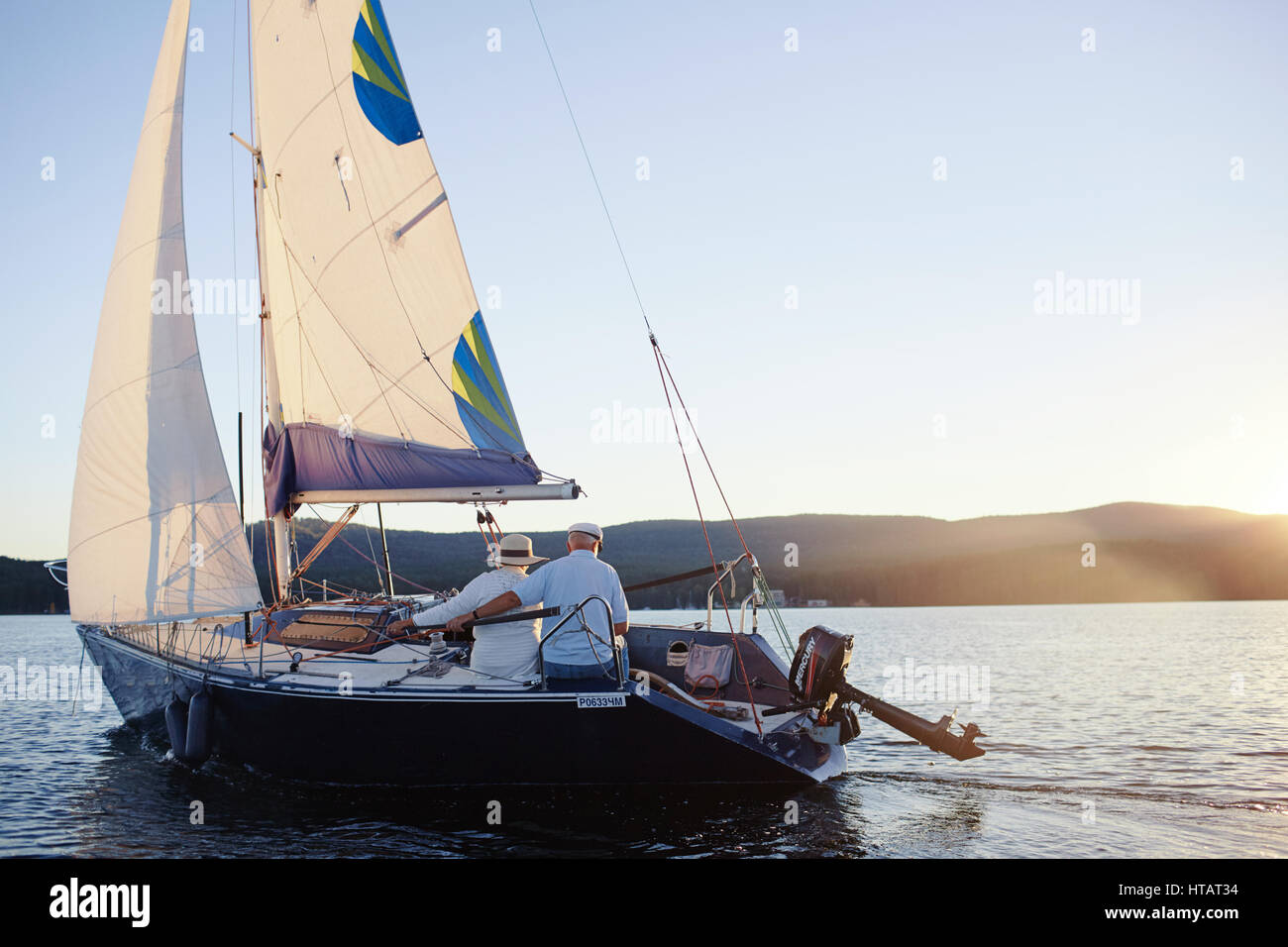 Rear view of relaxing couple sailing on yacht Stock Photo - Alamy