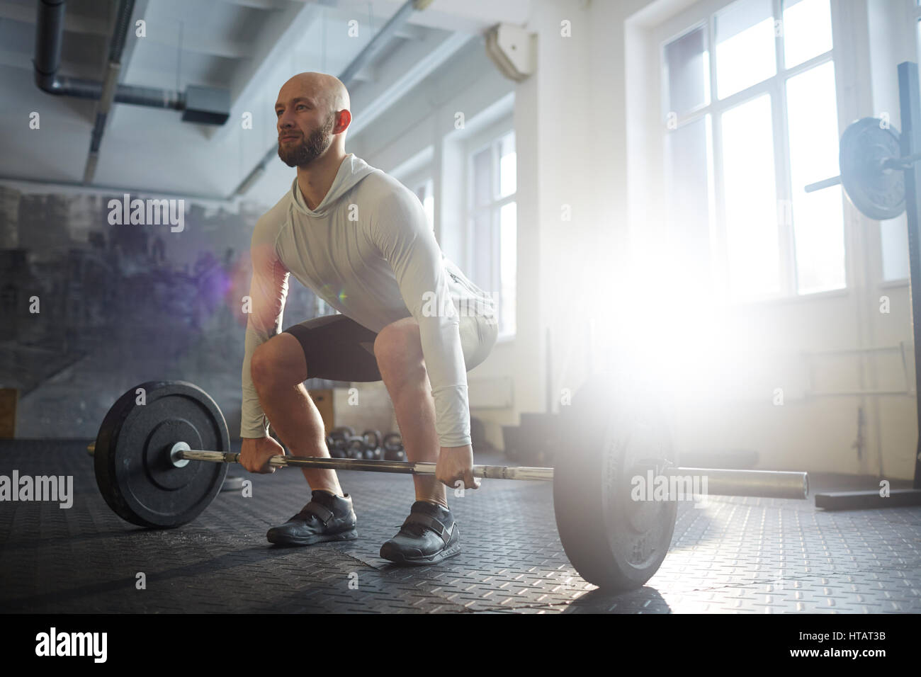 Young athlete lifting heavy barbell in gym Stock Photo - Alamy
