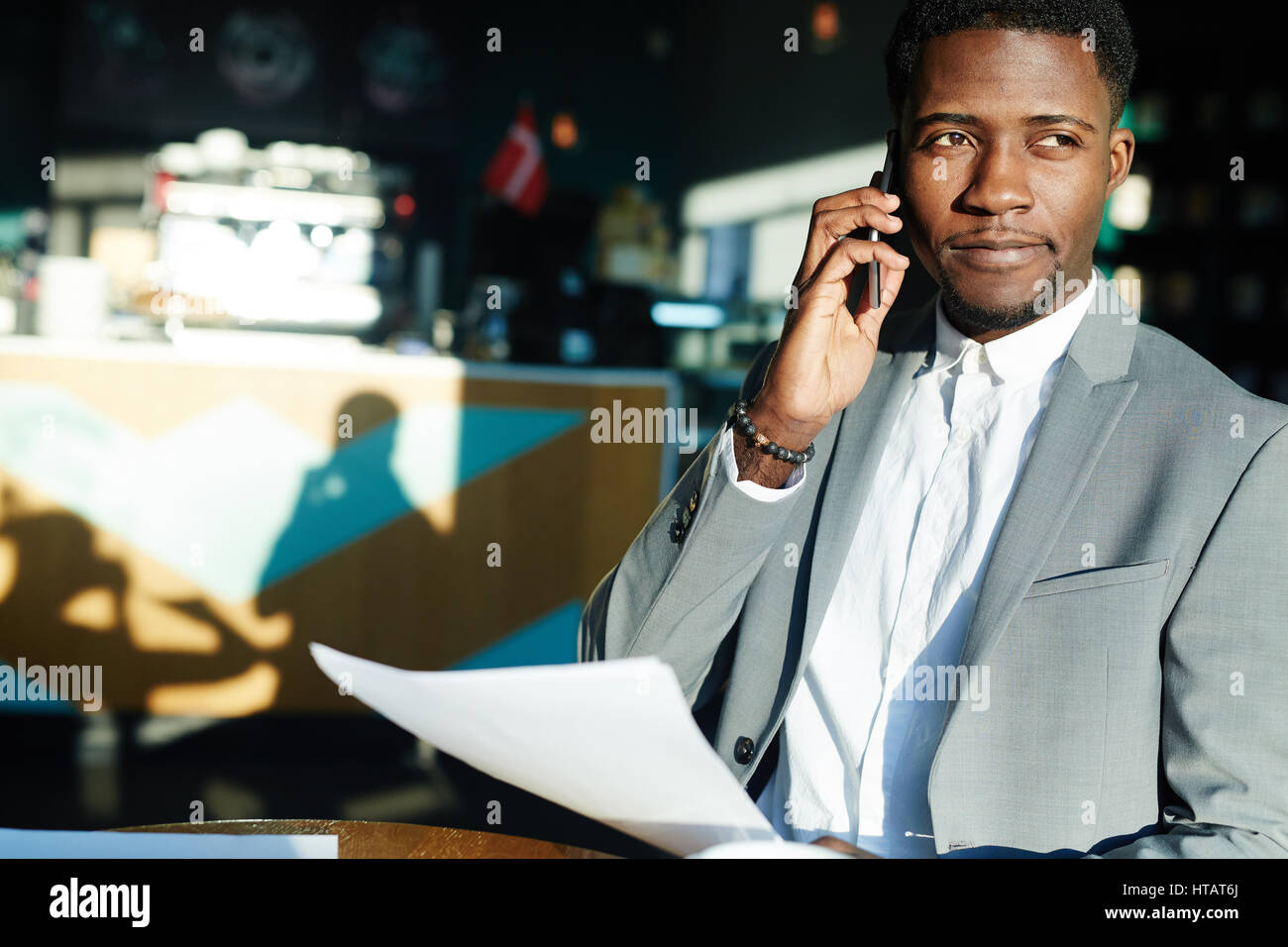 Busy broker with document speaking on smartphone Stock Photo - Alamy