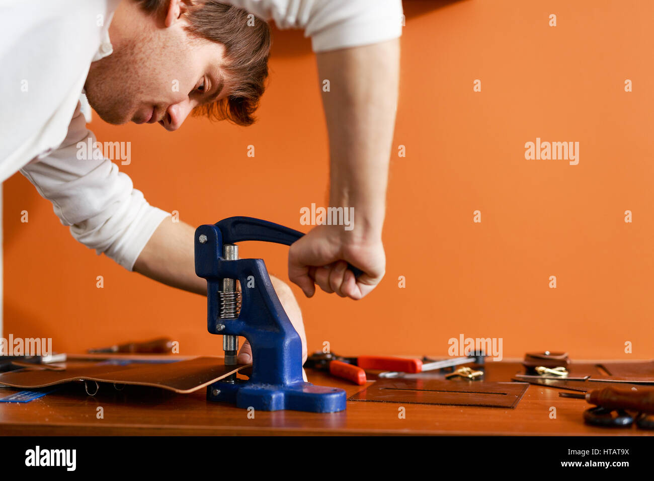 Master of leather production using stapler to pierce workpiece Stock ...