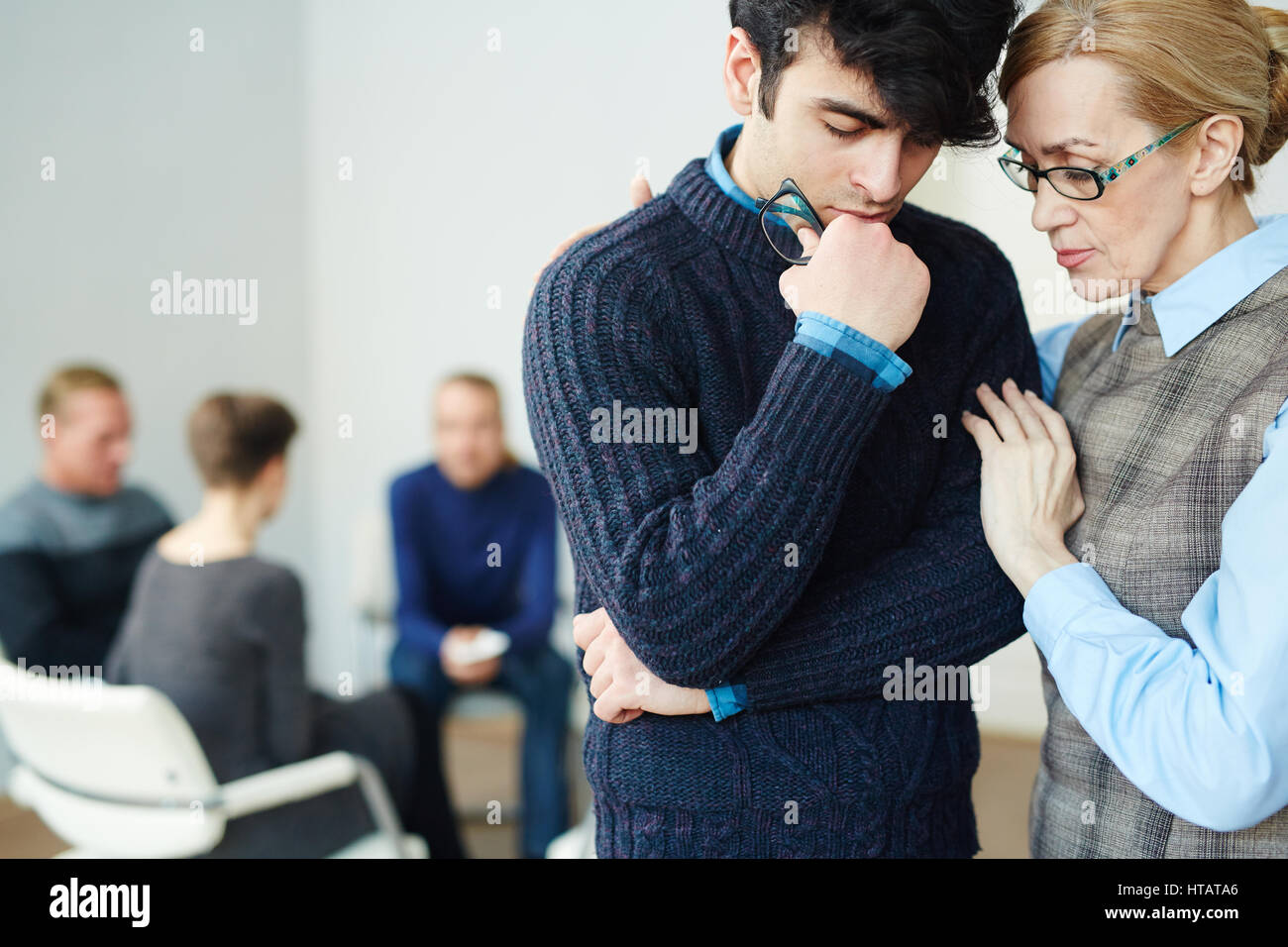 Sad man and his psychologist on background of humans Stock Photo - Alamy