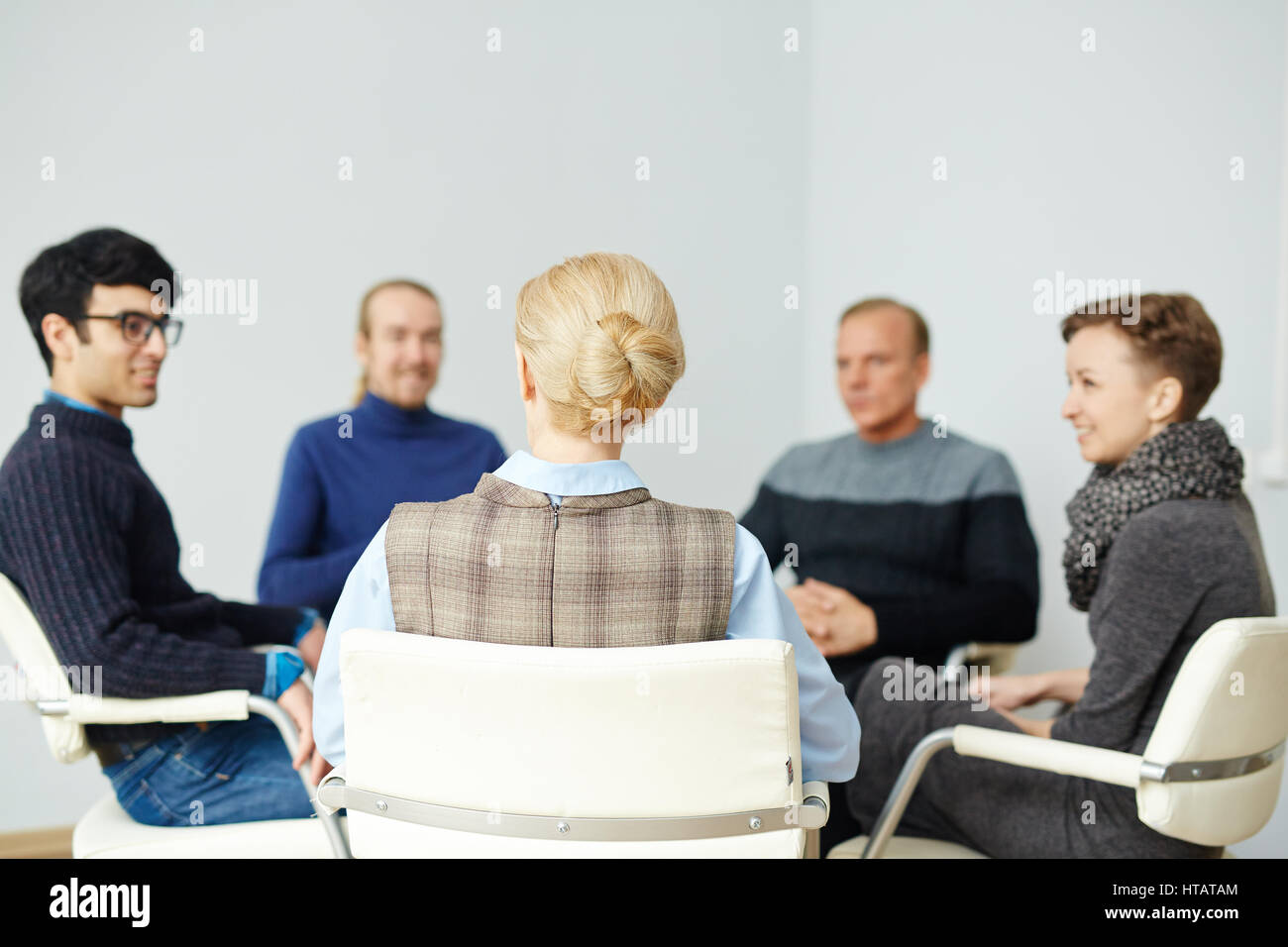 Rear view of counselor consulting young people Stock Photo - Alamy