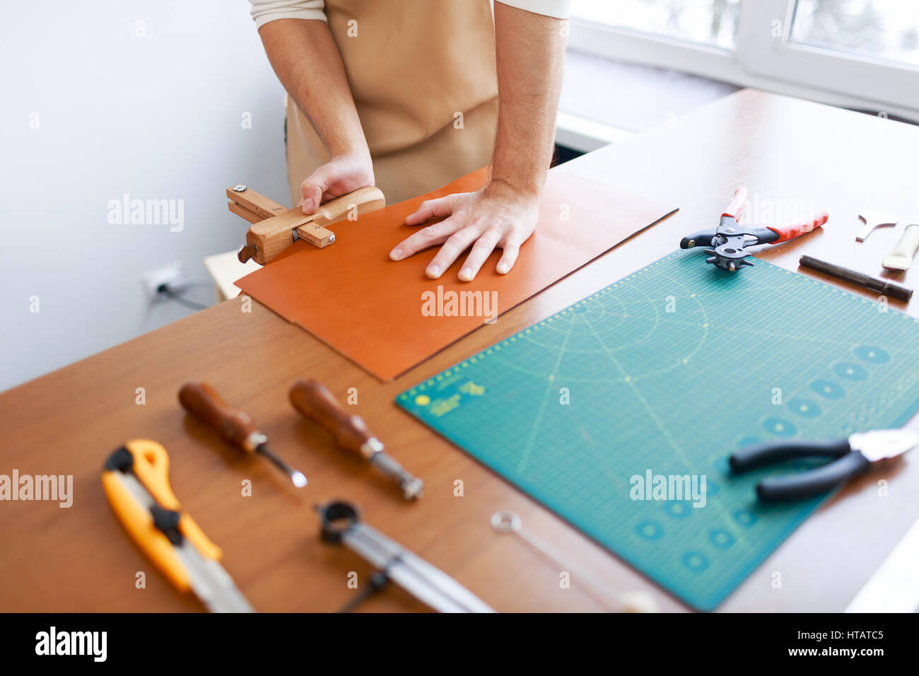 Leathercraftsman measuring workpiece at work Stock Photo - Alamy