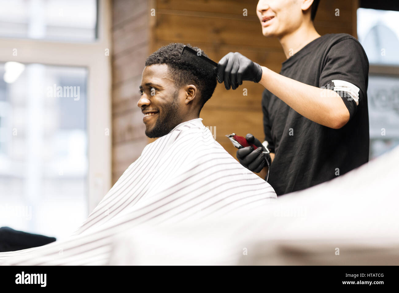 Barber taking care of his client hair Stock Photo - Alamy