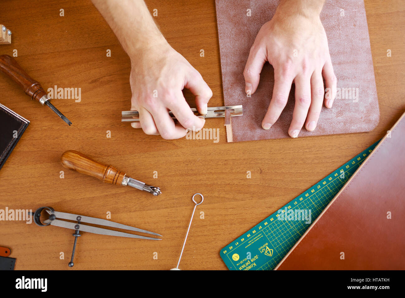 Human hands cutting leather workpiece on table Stock Photo - Alamy