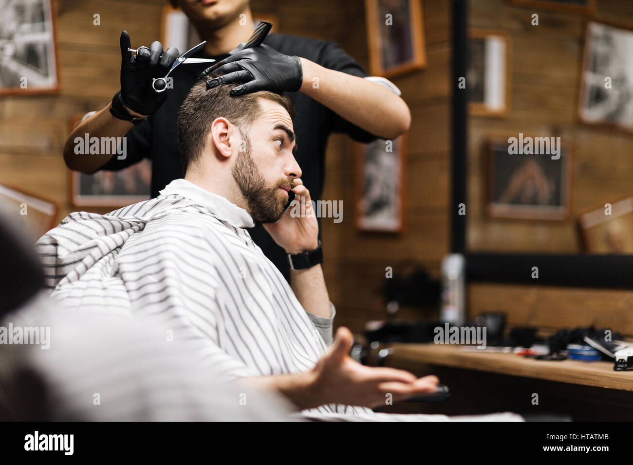 Man talking on smartphone during haircut process Stock Photo - Alamy