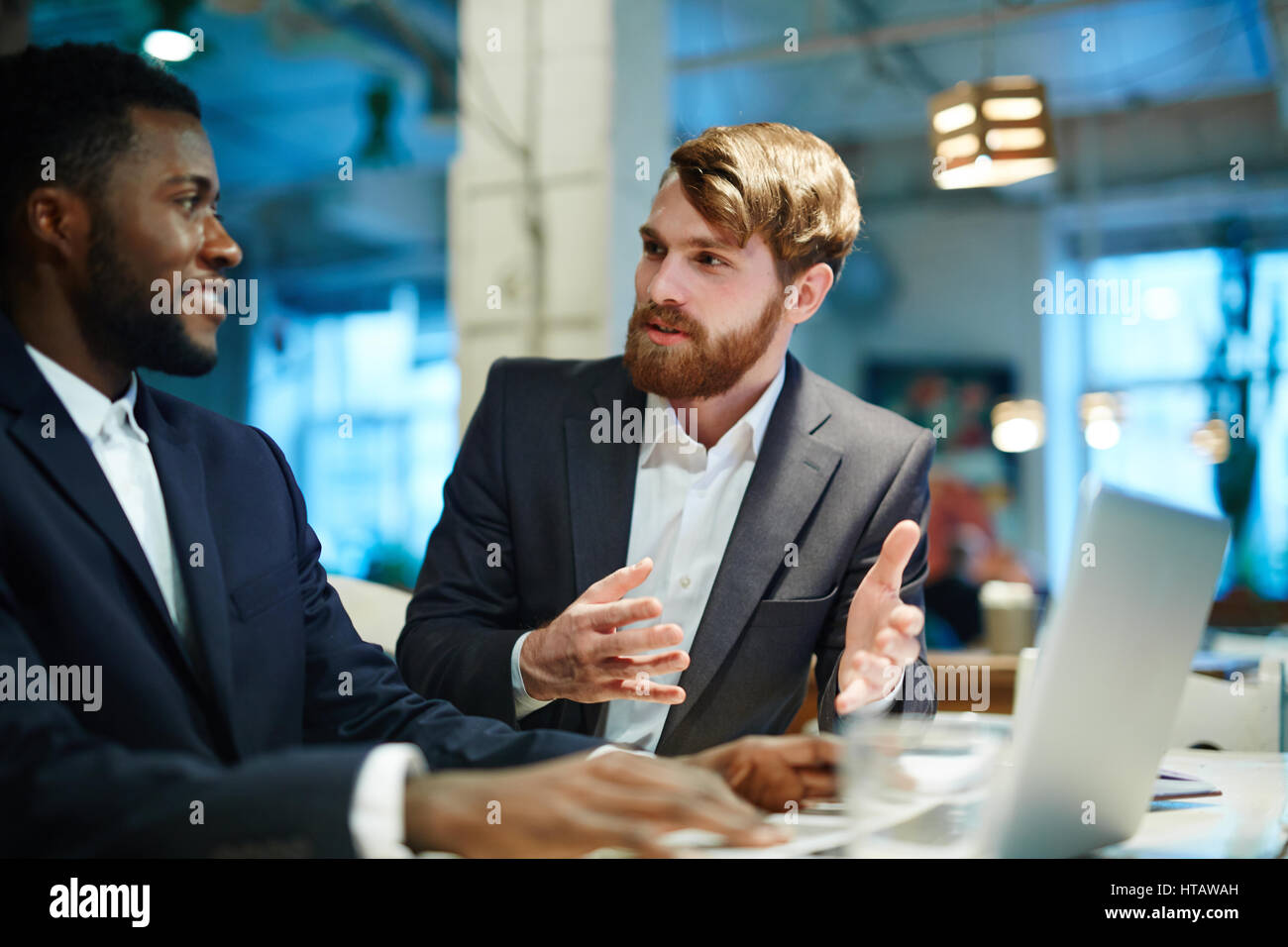 Intercultural colleagues discussing working hi-res stock photography ...