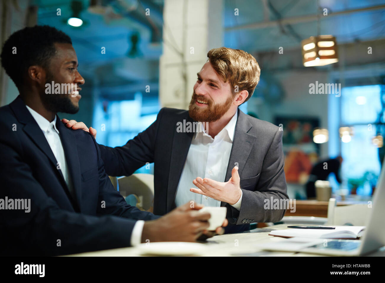 Two intercultural traders having discussion at meeting Stock Photo - Alamy