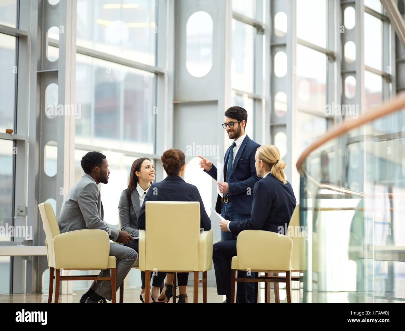 Young businessman answering questions of his colleagues after report ...