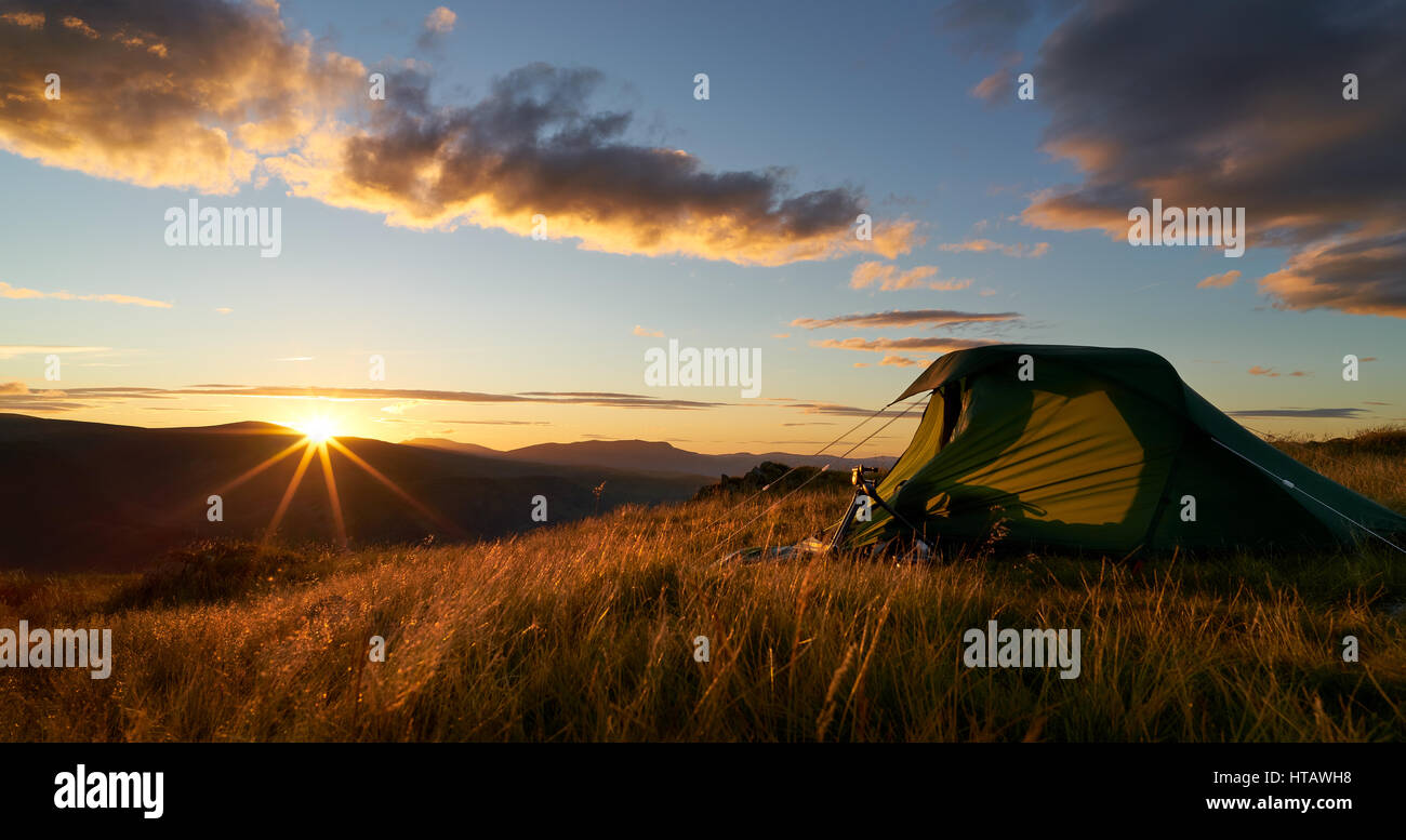 A hiker camping on the mountain summit of Place Fell in the Lake ...
