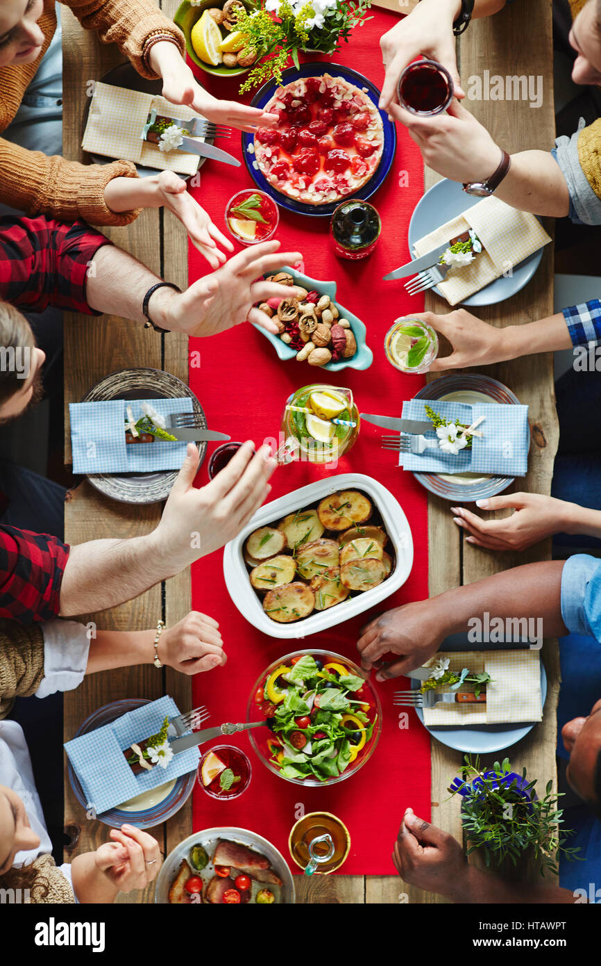 Group of friends talking by served festive table Stock Photo - Alamy