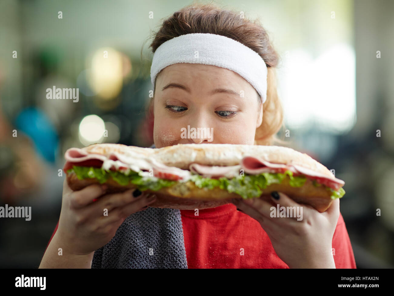 Closeup portrait of young obese woman holding big fattening sandwich in ...