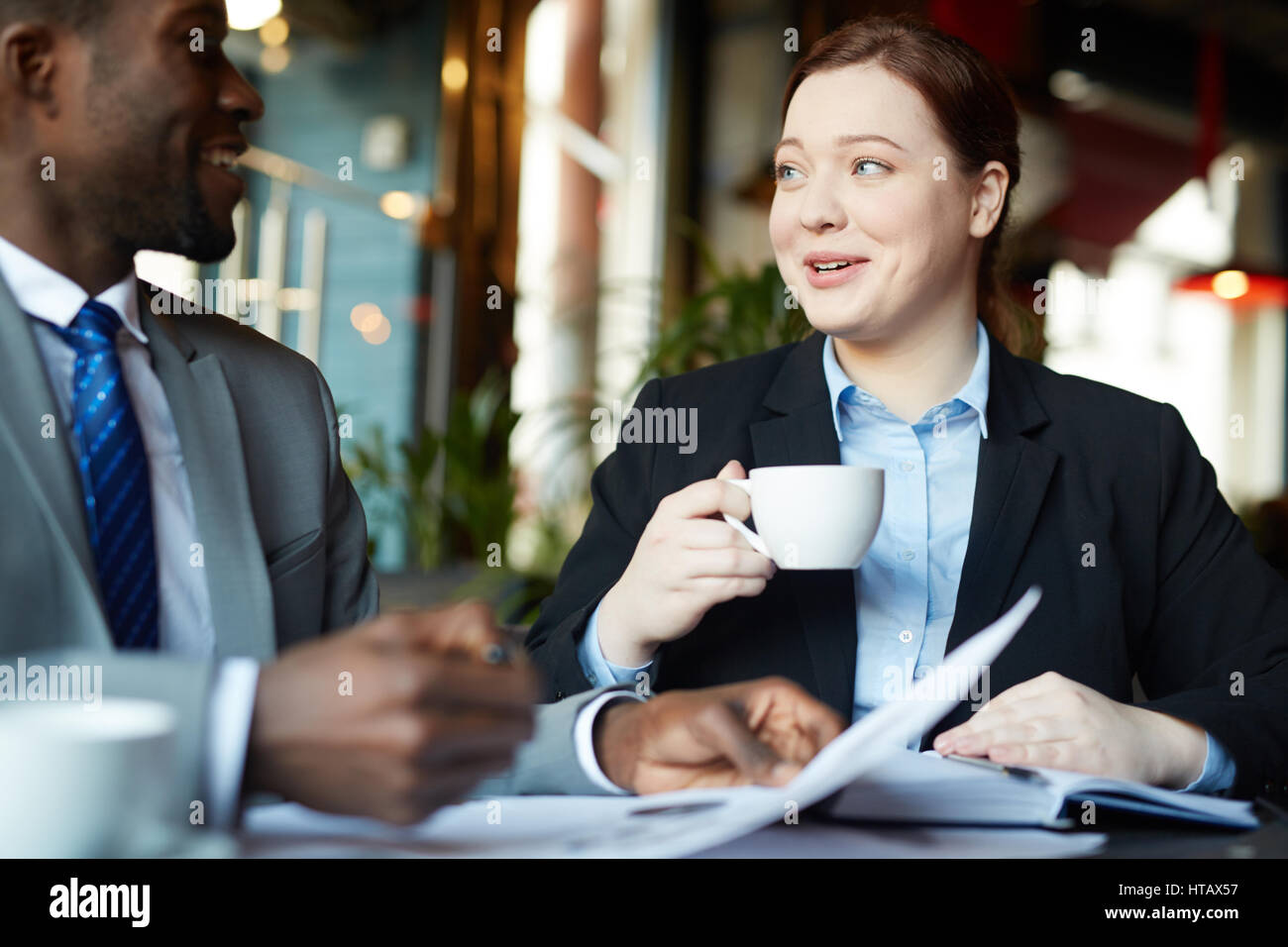 Portrait of two business people during work meeting in modern cafe ...