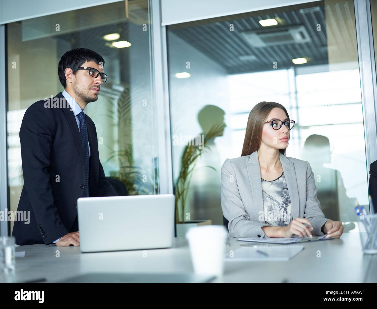 Serious colleagues listening to explanation in office Stock Photo - Alamy