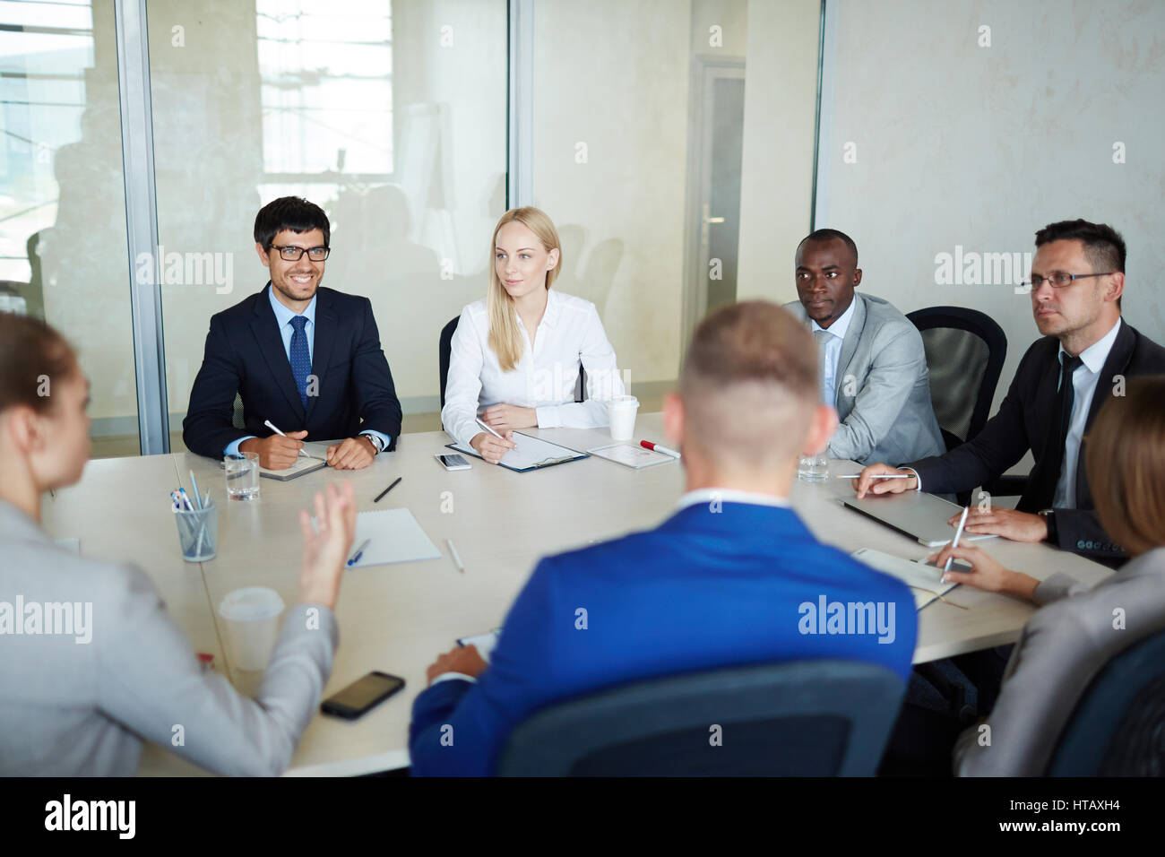 Group of professionals having discussion at working meeting in office ...