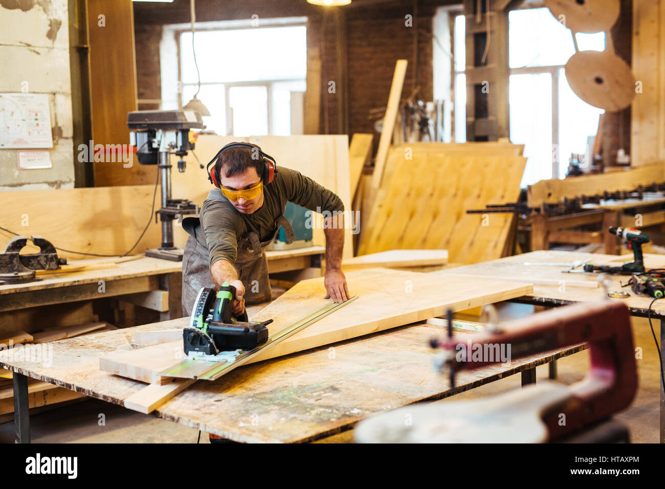 Woodworking artisan cutting wooden plank Stock Photo - Alamy