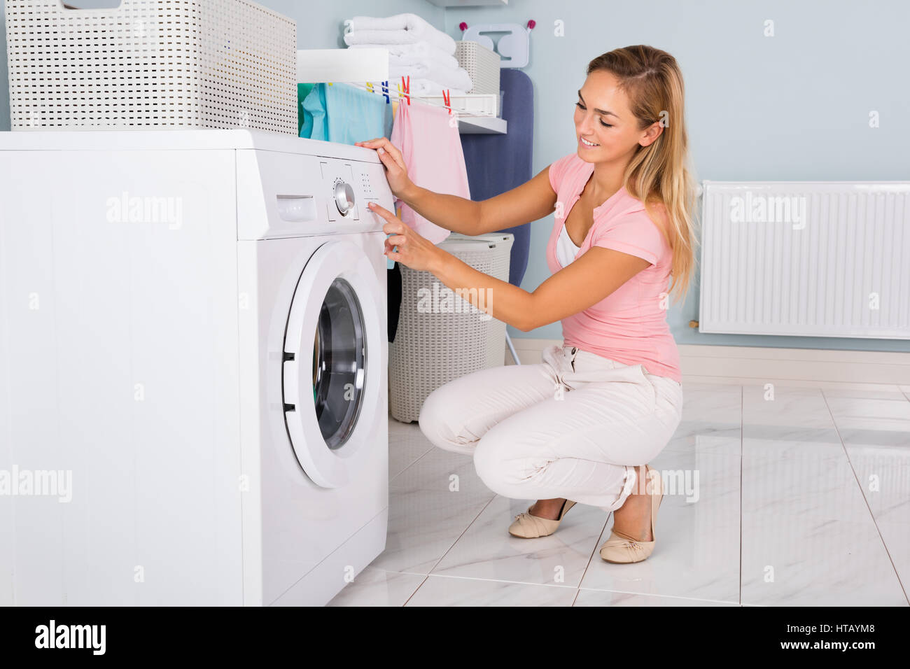Young Happy Woman Using Washing Machine In Utility Room Stock Photo - Alamy