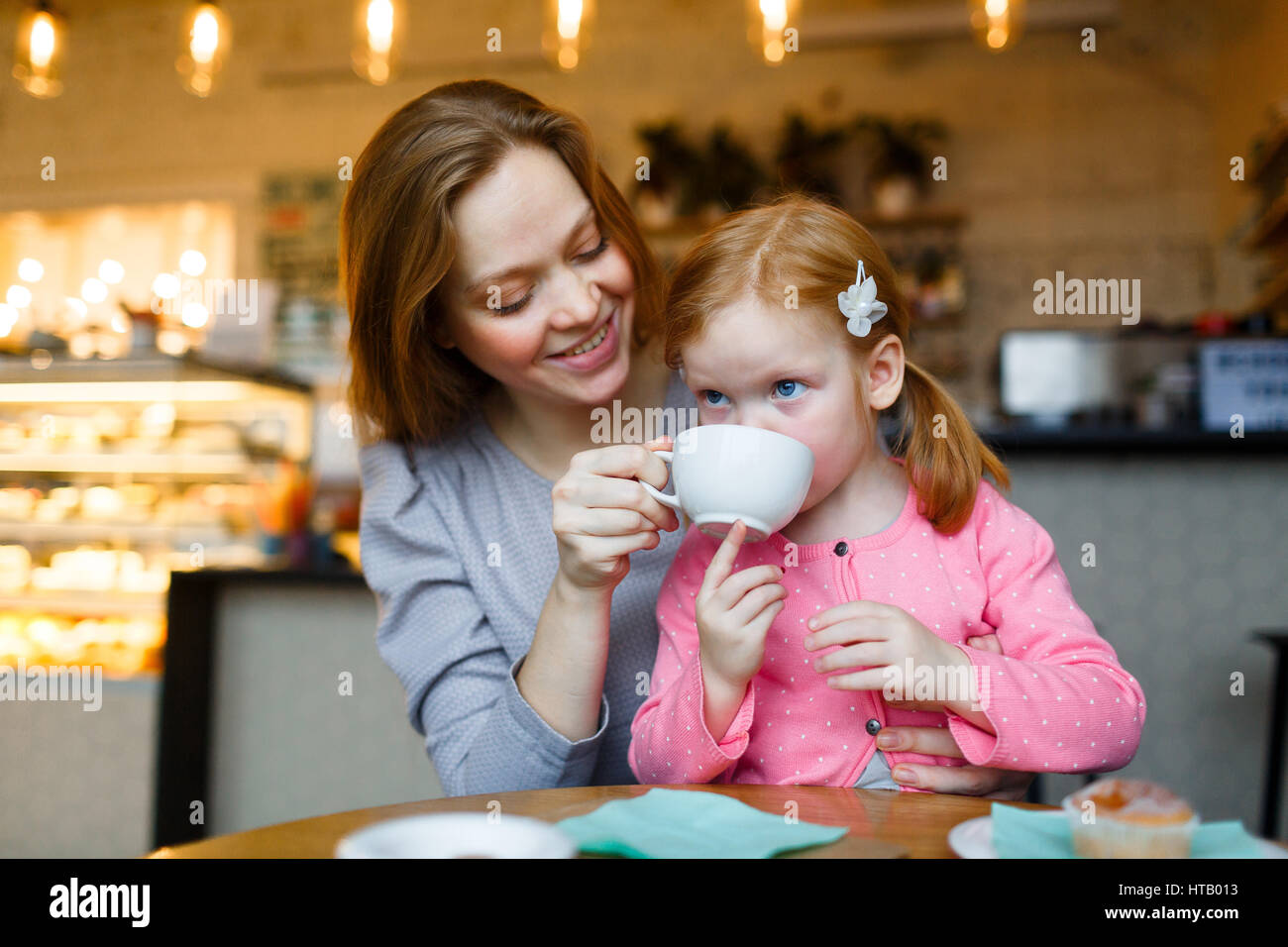 Restful woman giving her daughter drink Stock Photo - Alamy