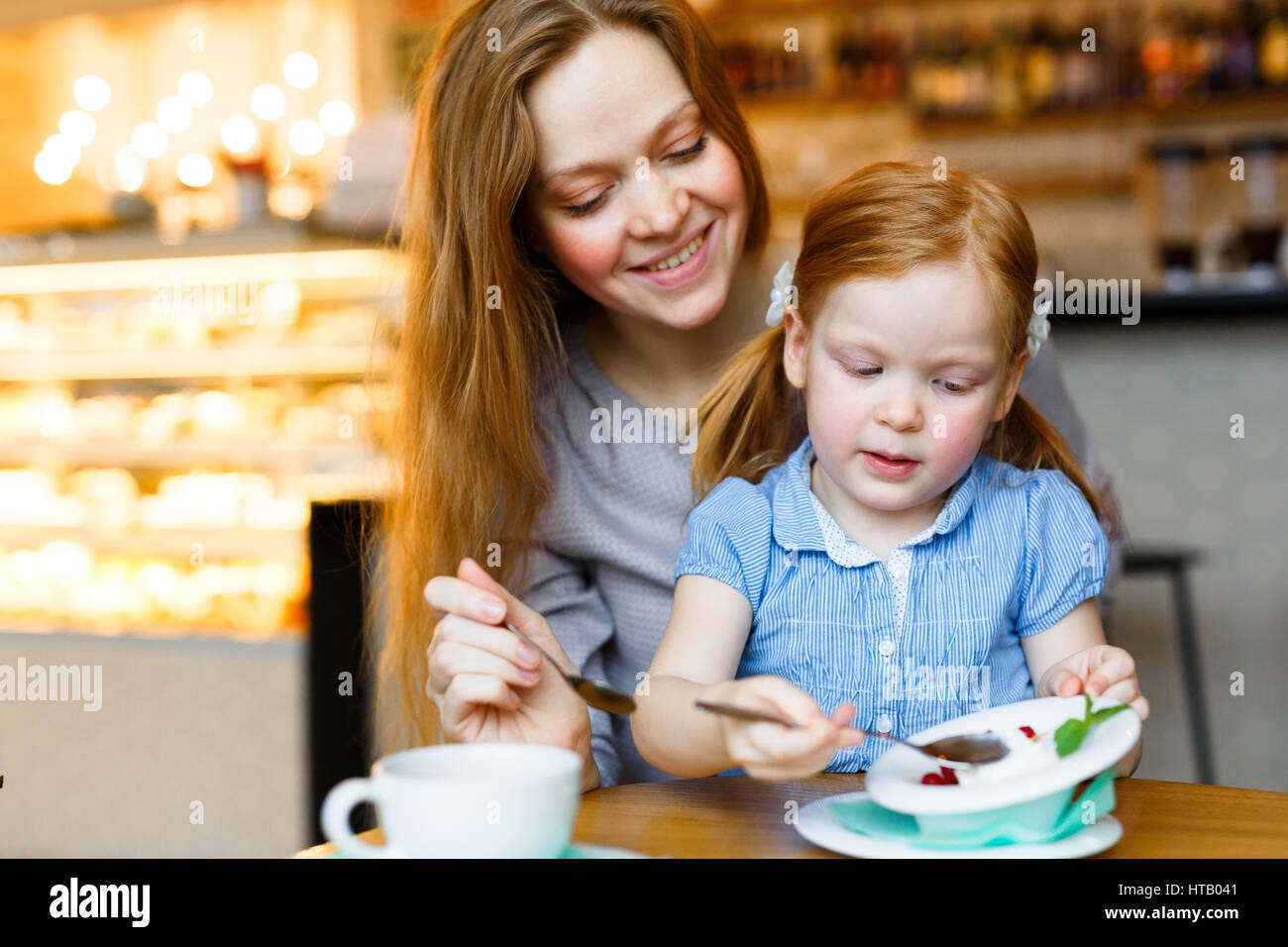 Happy woman and her daughter having dessert in cafe Stock Photo - Alamy