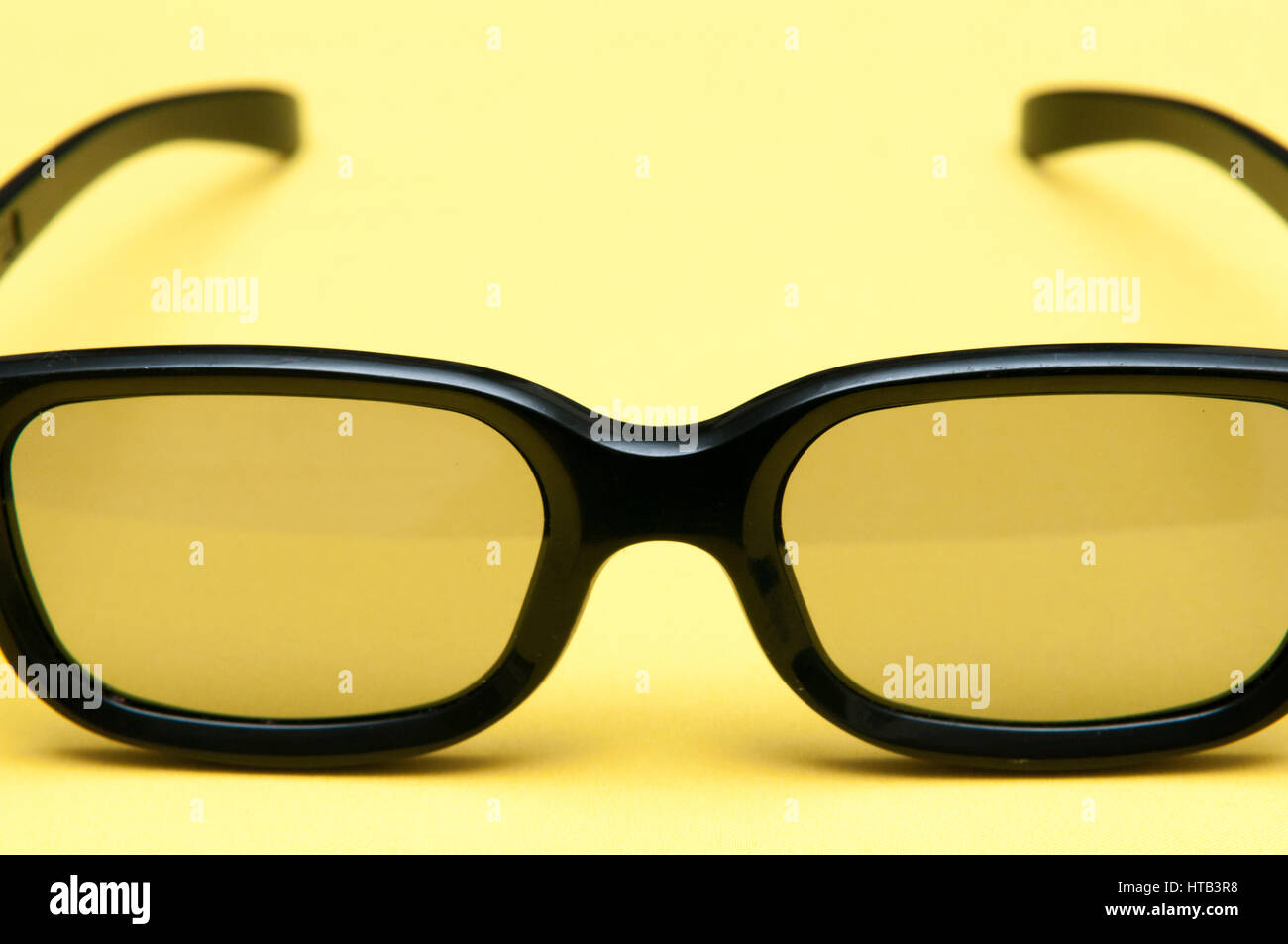 Glasses with black frame on yellow background Stock Photo - Alamy