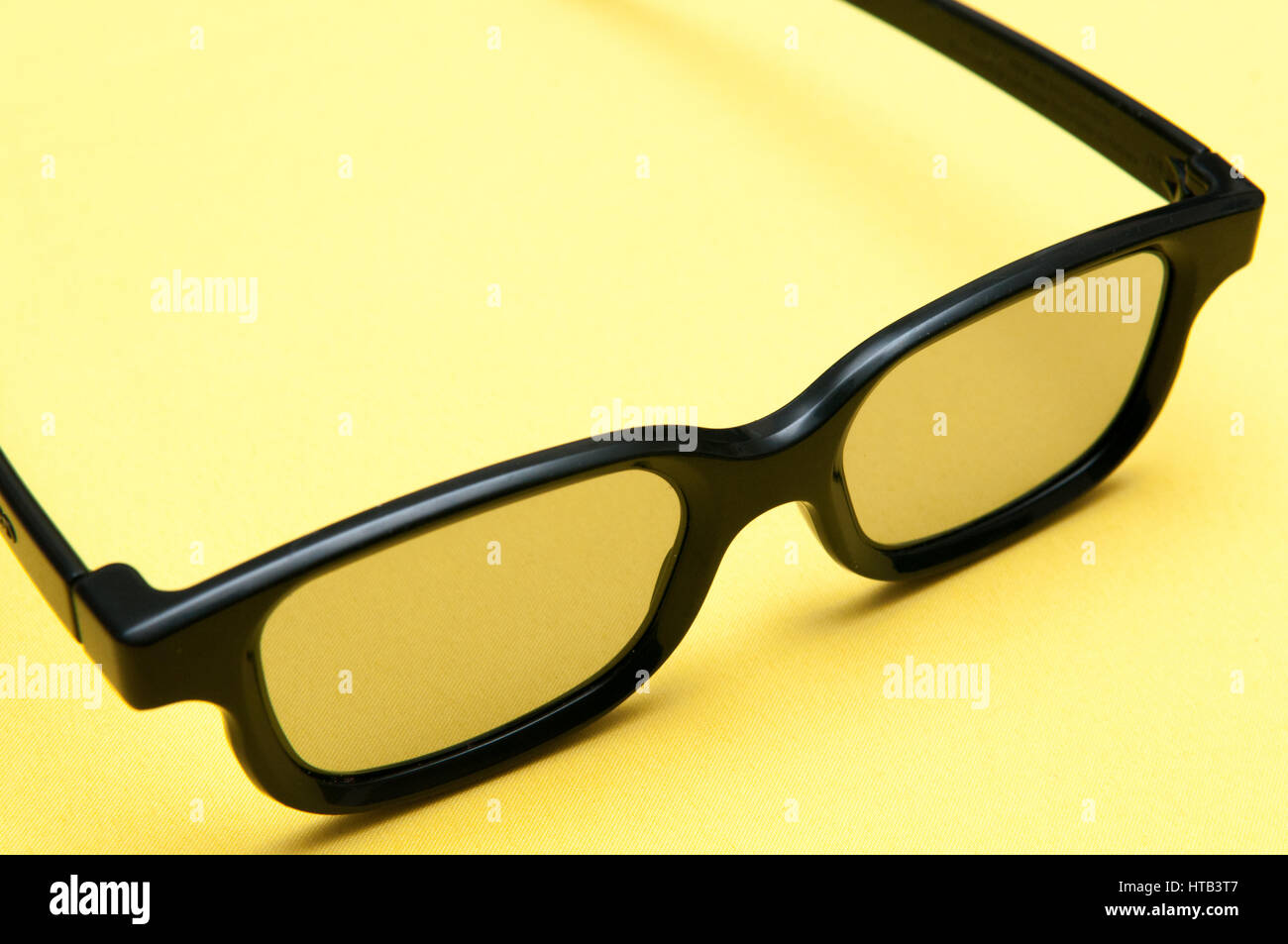 Glasses with black frame on yellow background Stock Photo - Alamy