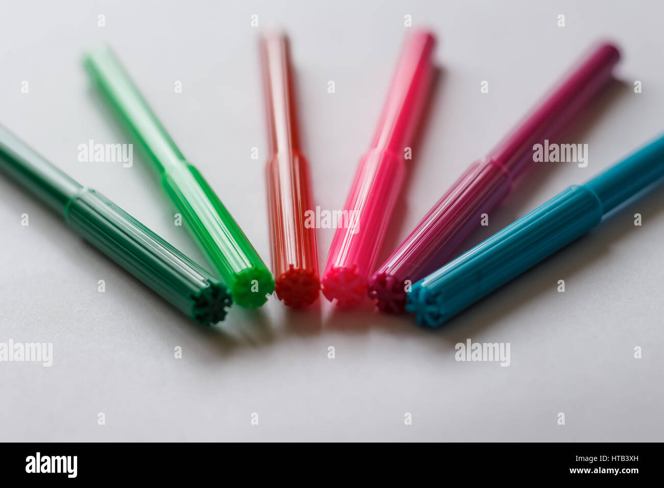 colored markers with caps on white paper blurred background Stock Photo ...