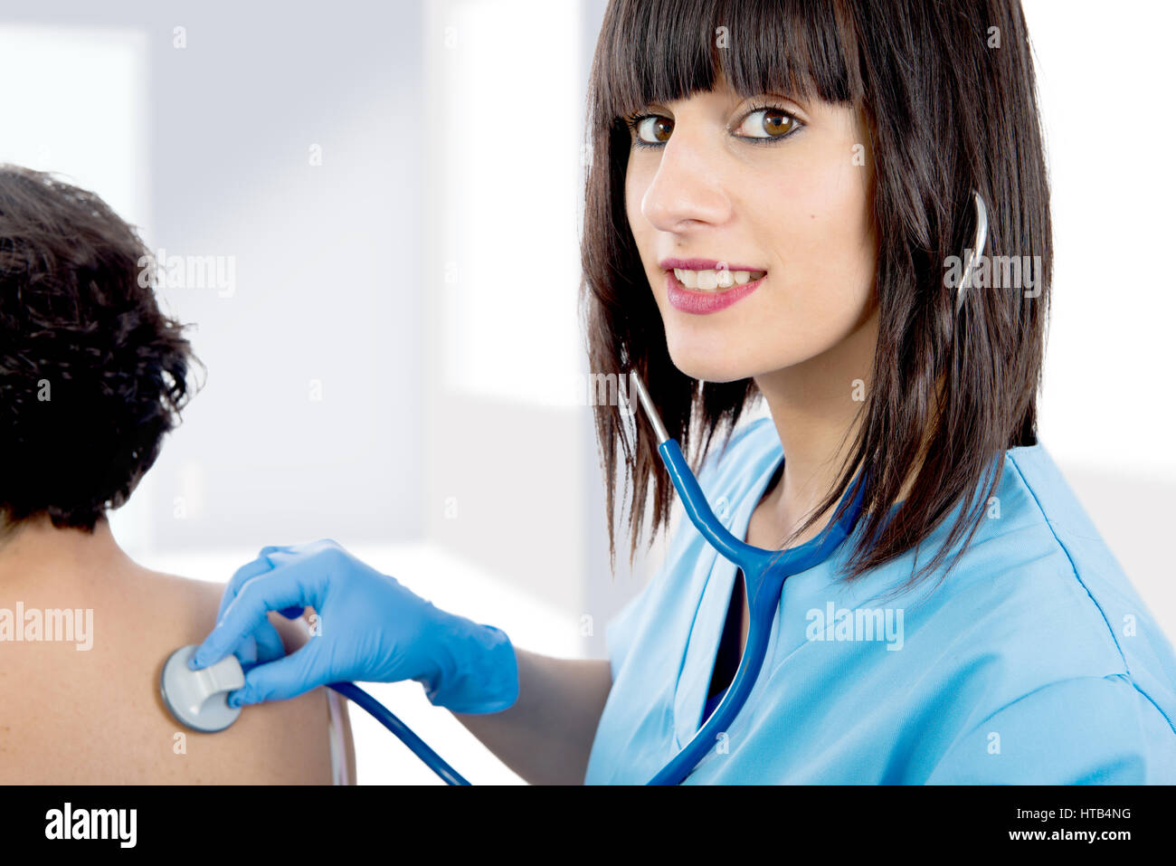 young female doctor examines a patient with a stethoscope Stock Photo ...