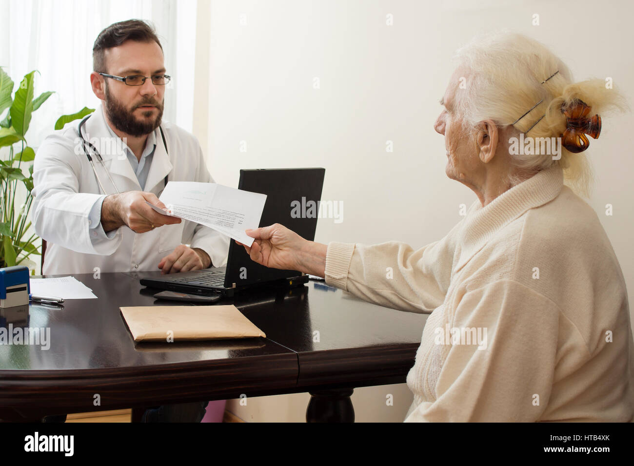 geriatrician doctor with a patient in his office. The doctor ...
