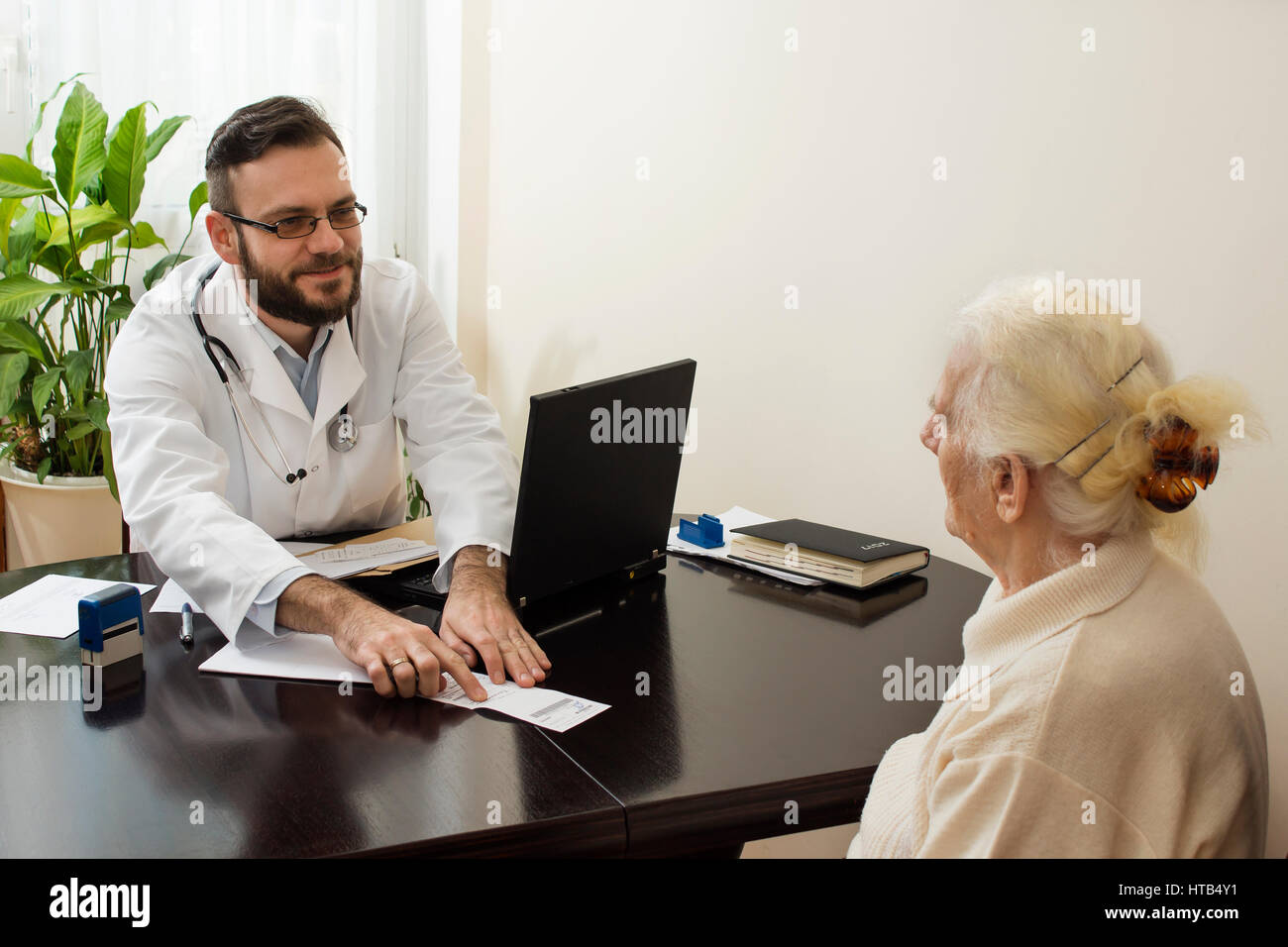 A doctor at work. He shows a finger and translates the patient record ...