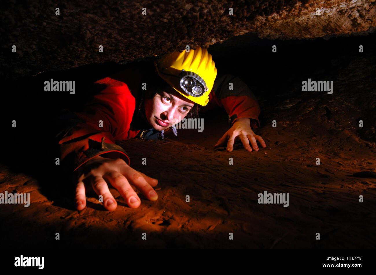 A narrow cave passage with a cave explorer Stock Photo - Alamy