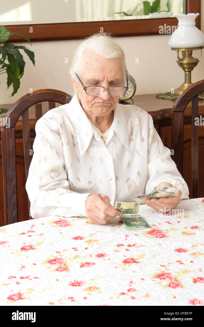 Pension. Old woman counts the money. Old woman with a sad face counts ...