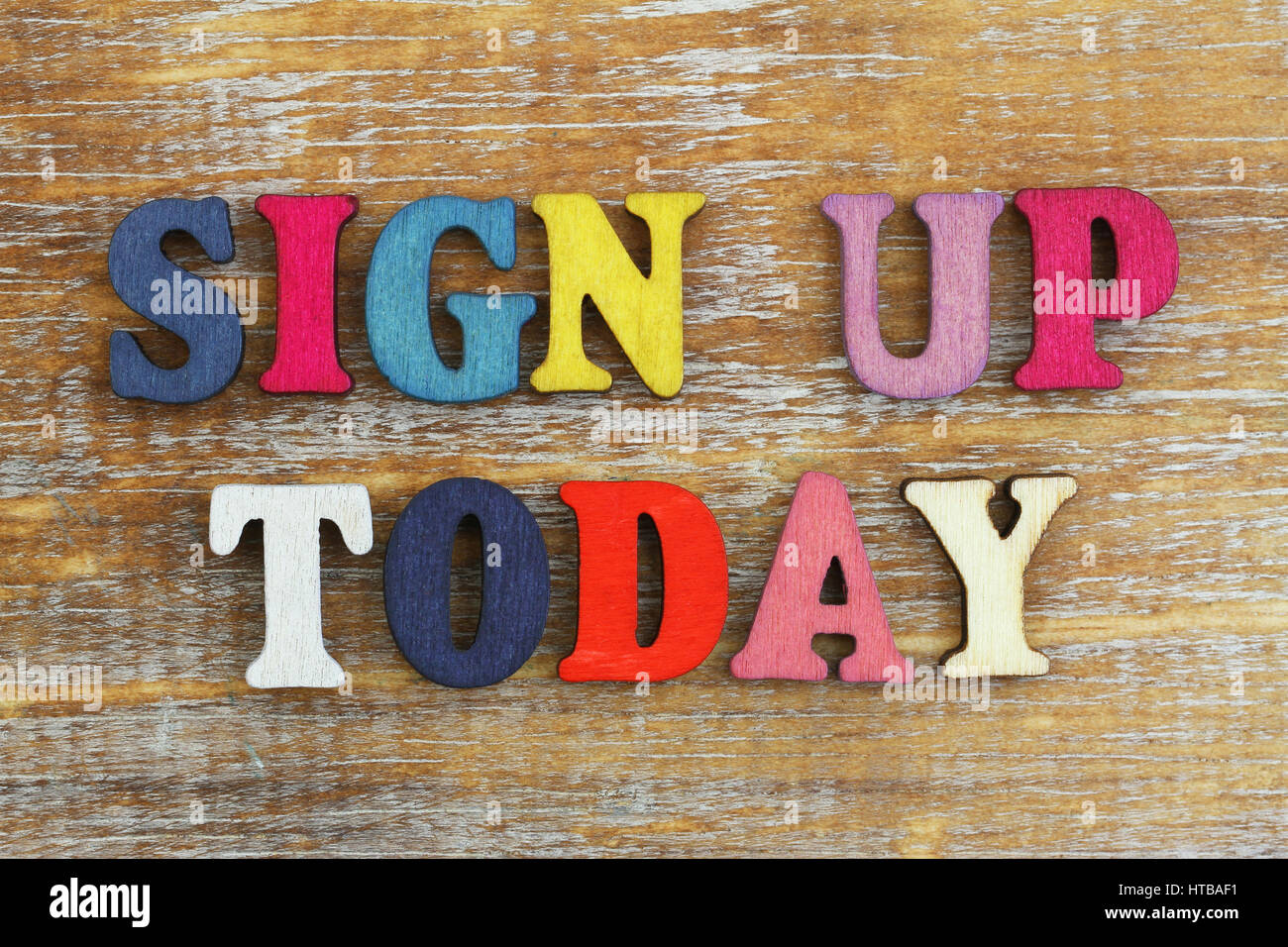 Sign up today written with colorful letters on rustic wooden surface ...
