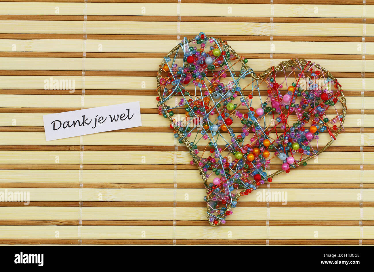 Dank je wel (thank you in Dutch) with heart made of colorful beads on ...