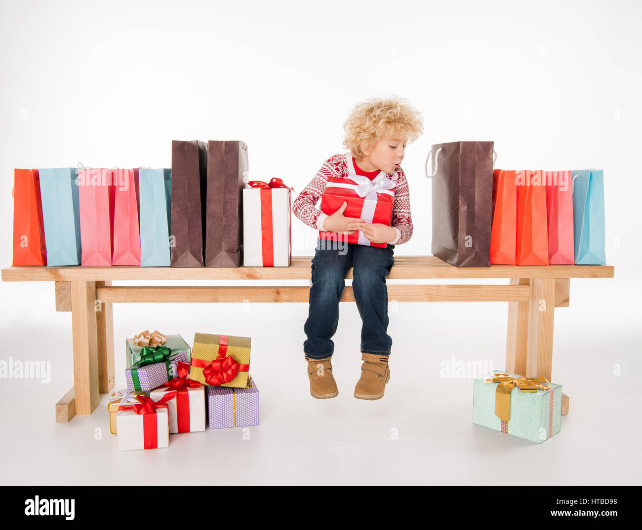 Kid with pile of gift boxes sitting on table Stock Photo - Alamy