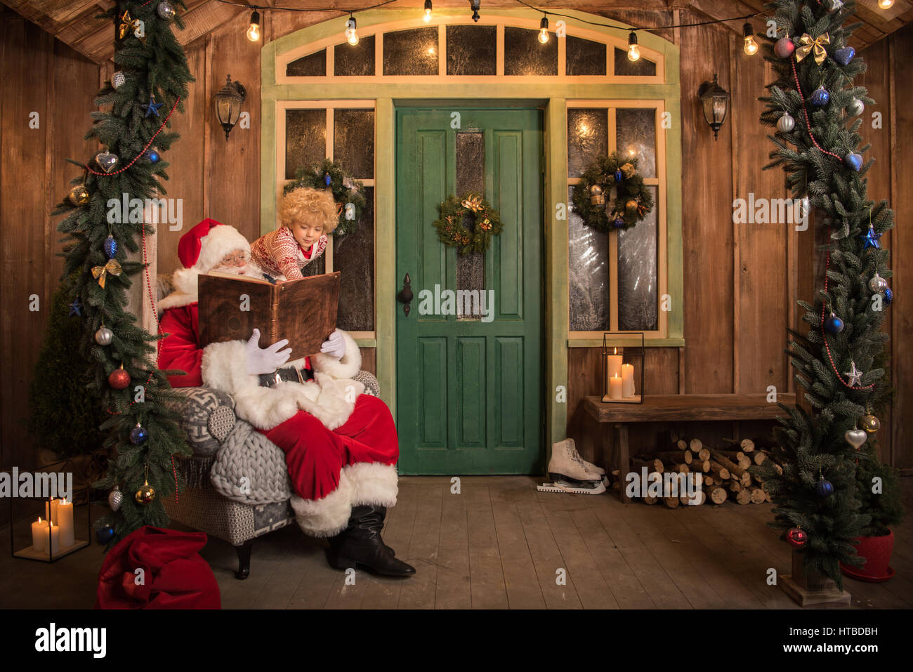 Santa Claus with child reading book at Christmas time Stock Photo - Alamy