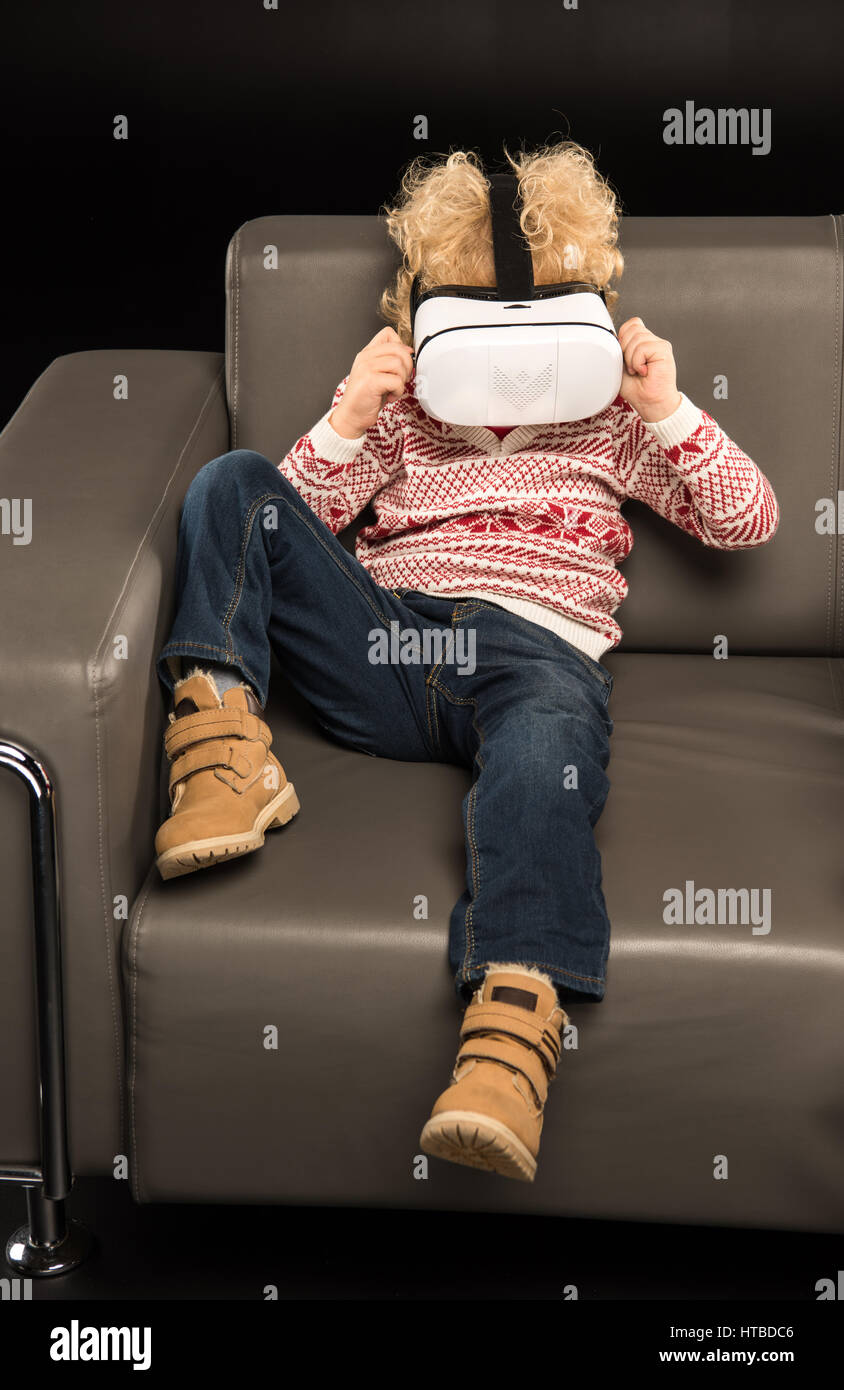 Kid using virtual reality headset on couch Stock Photo - Alamy