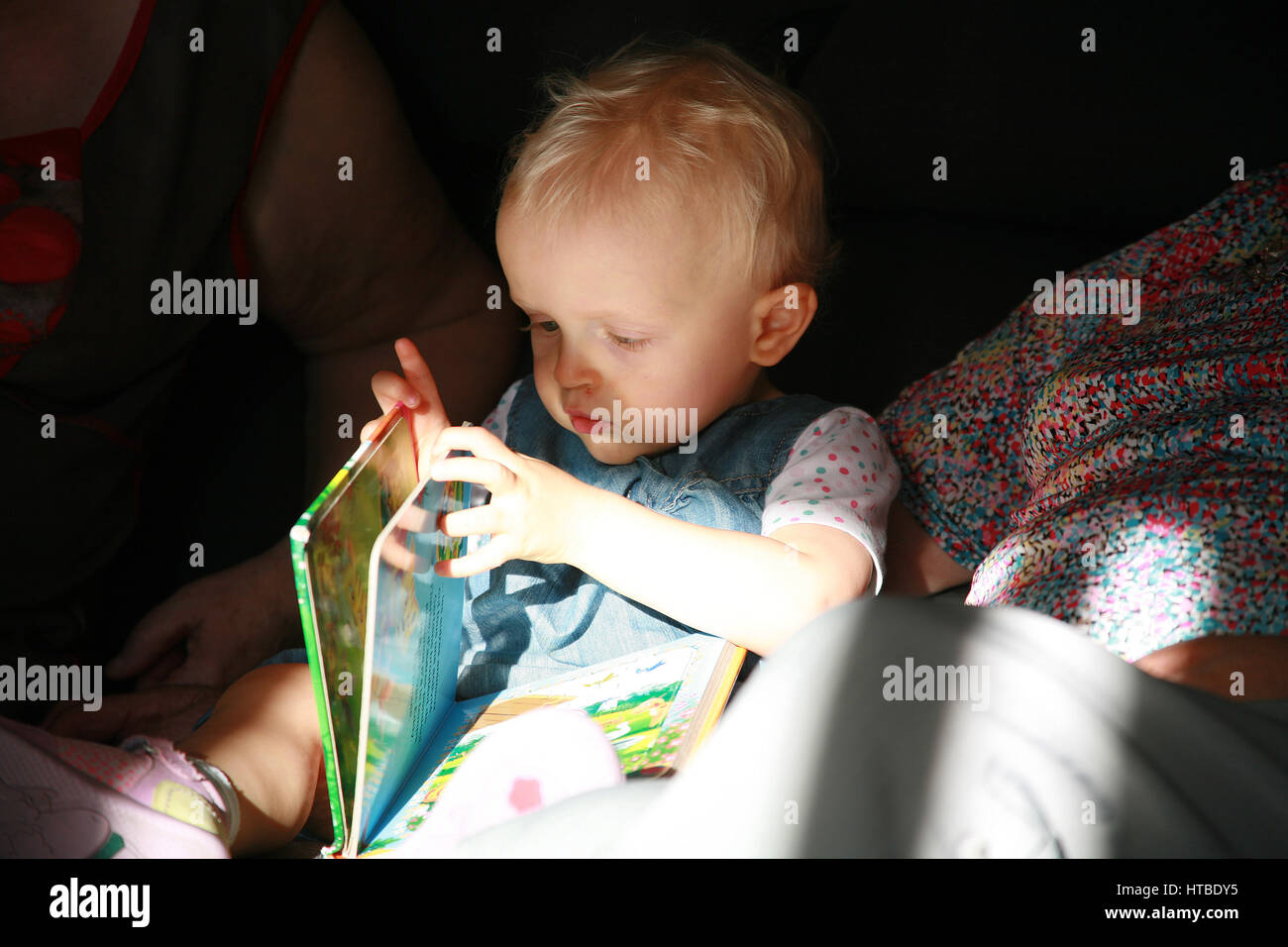 toddler girl reading a book Stock Photo - Alamy