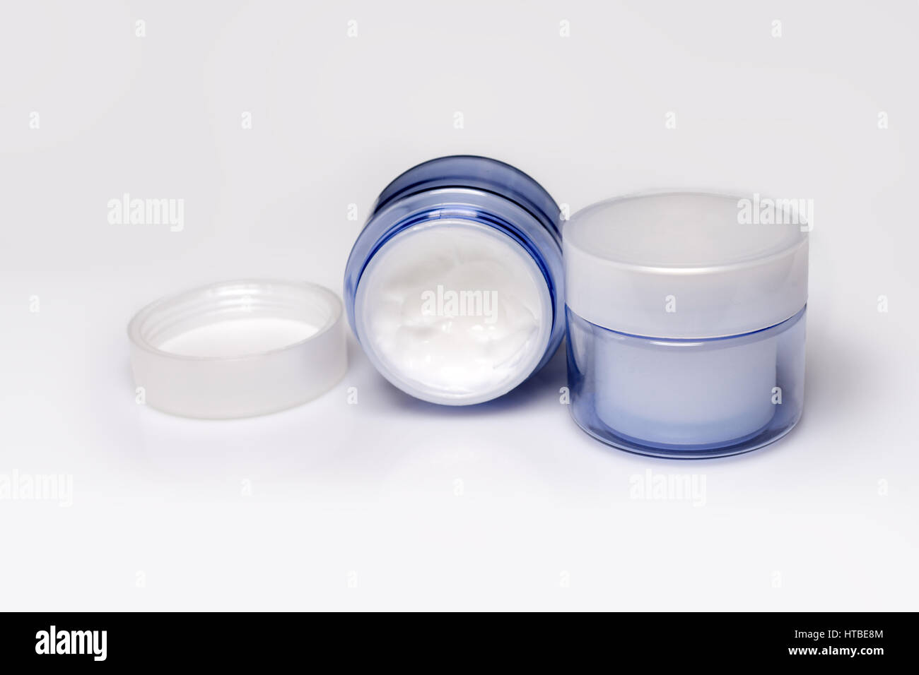 Two containers of moisturizing face cream on white background Stock ...